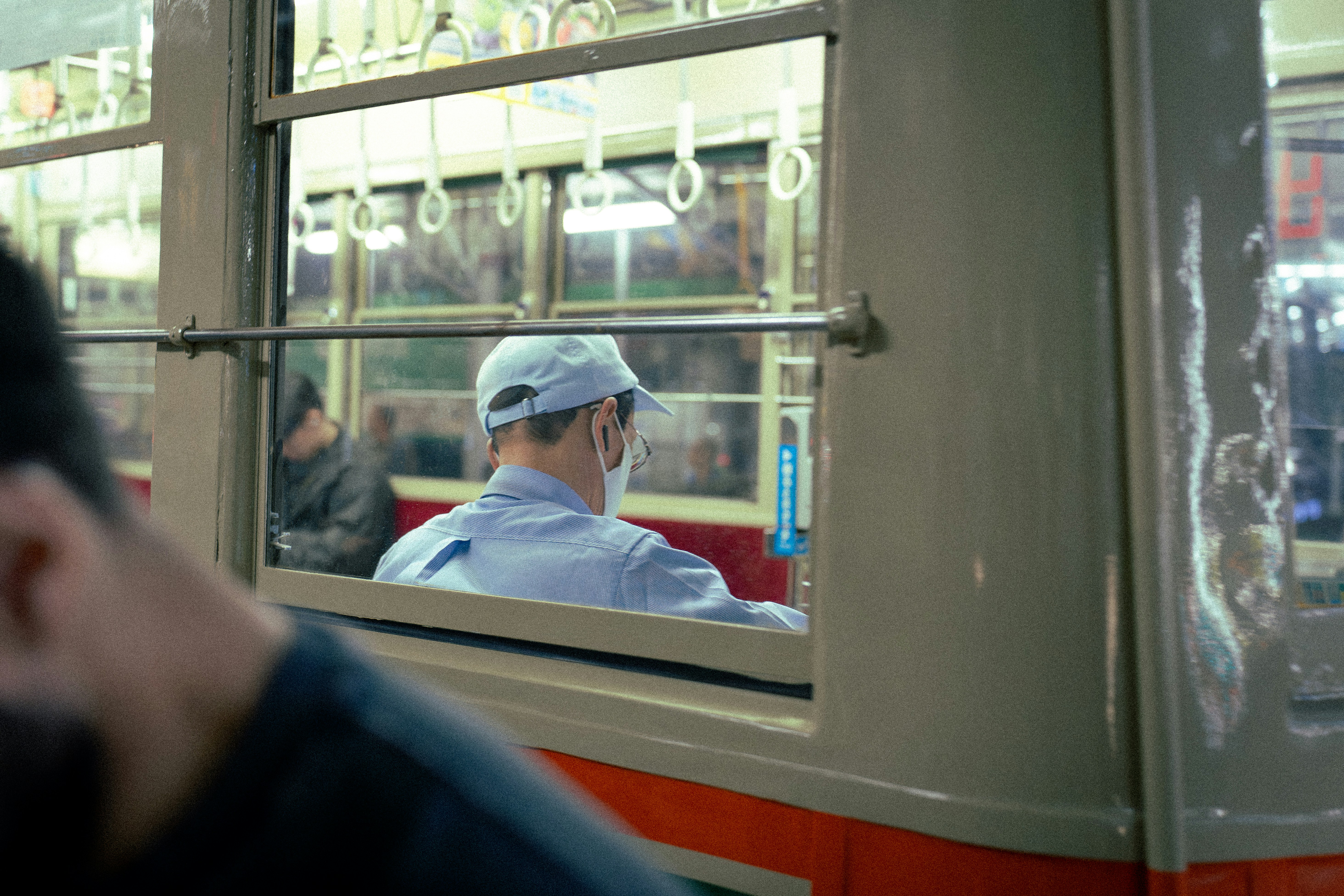 A Quiet Portrait Through a Window: The Sleeved Attendant in Transit