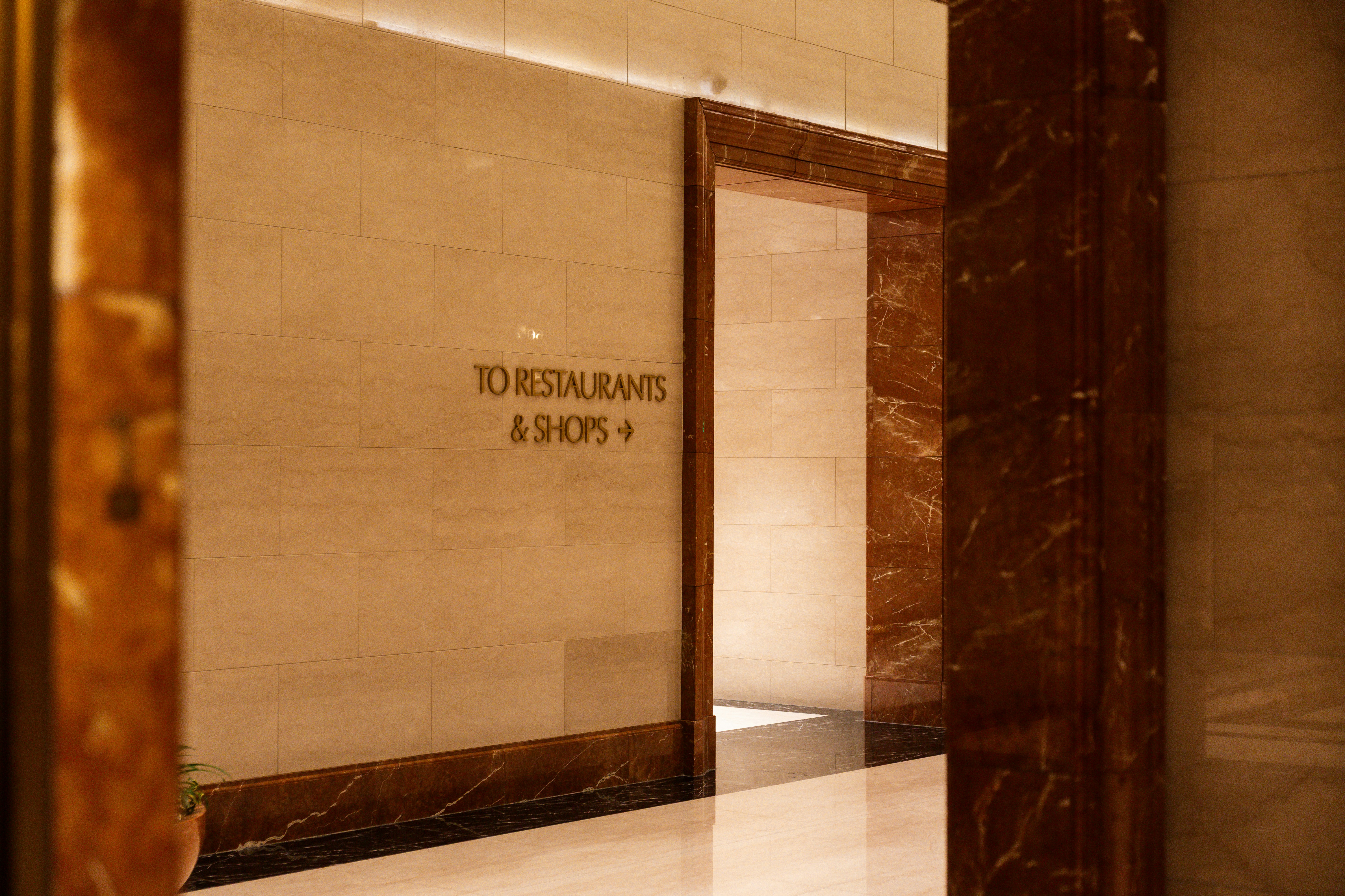 Amber Hallway Echoes: Signage by Marble Columns