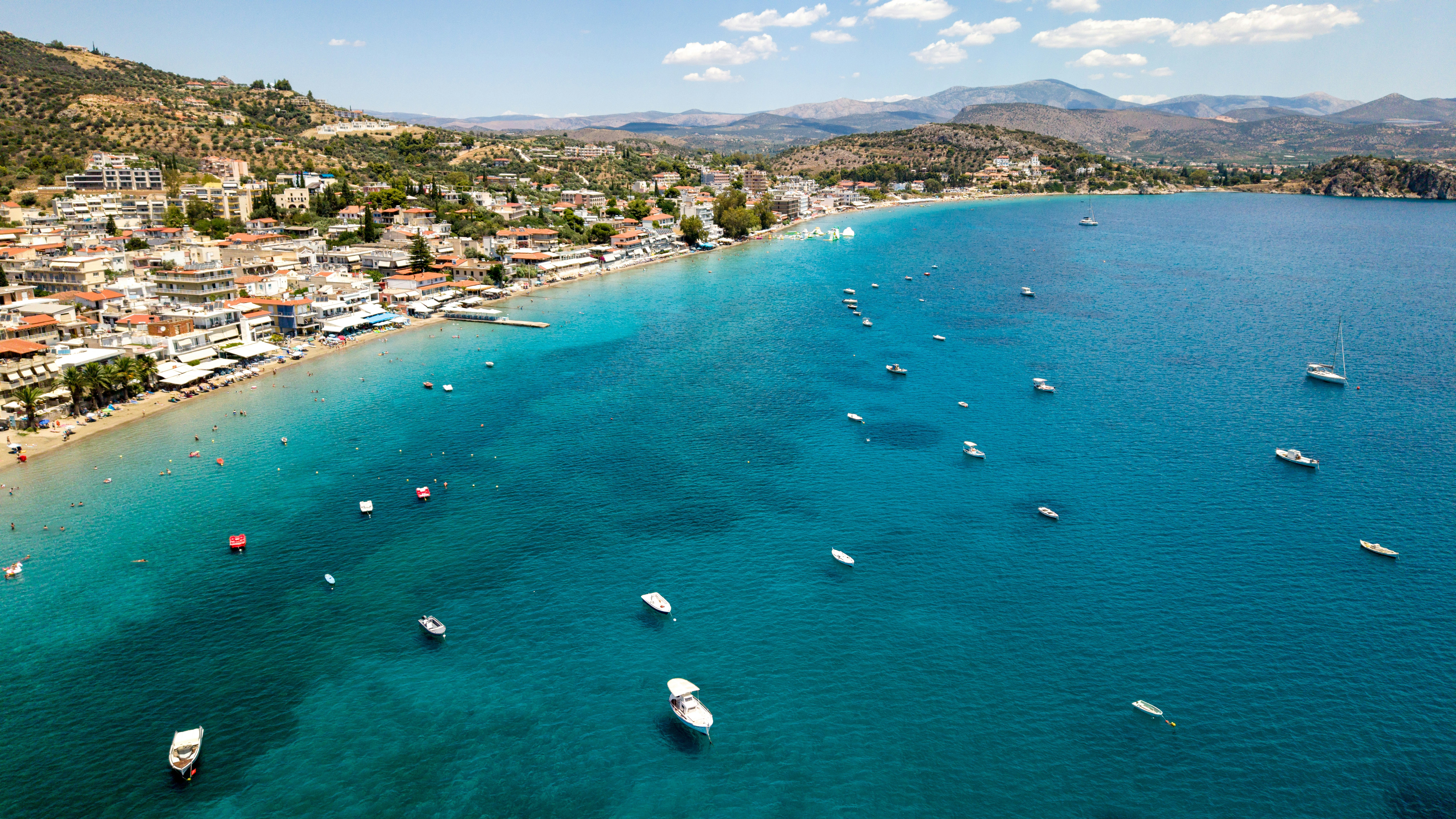 Azure Coastline: Boats, Beachfront Homes, and Distant Hills