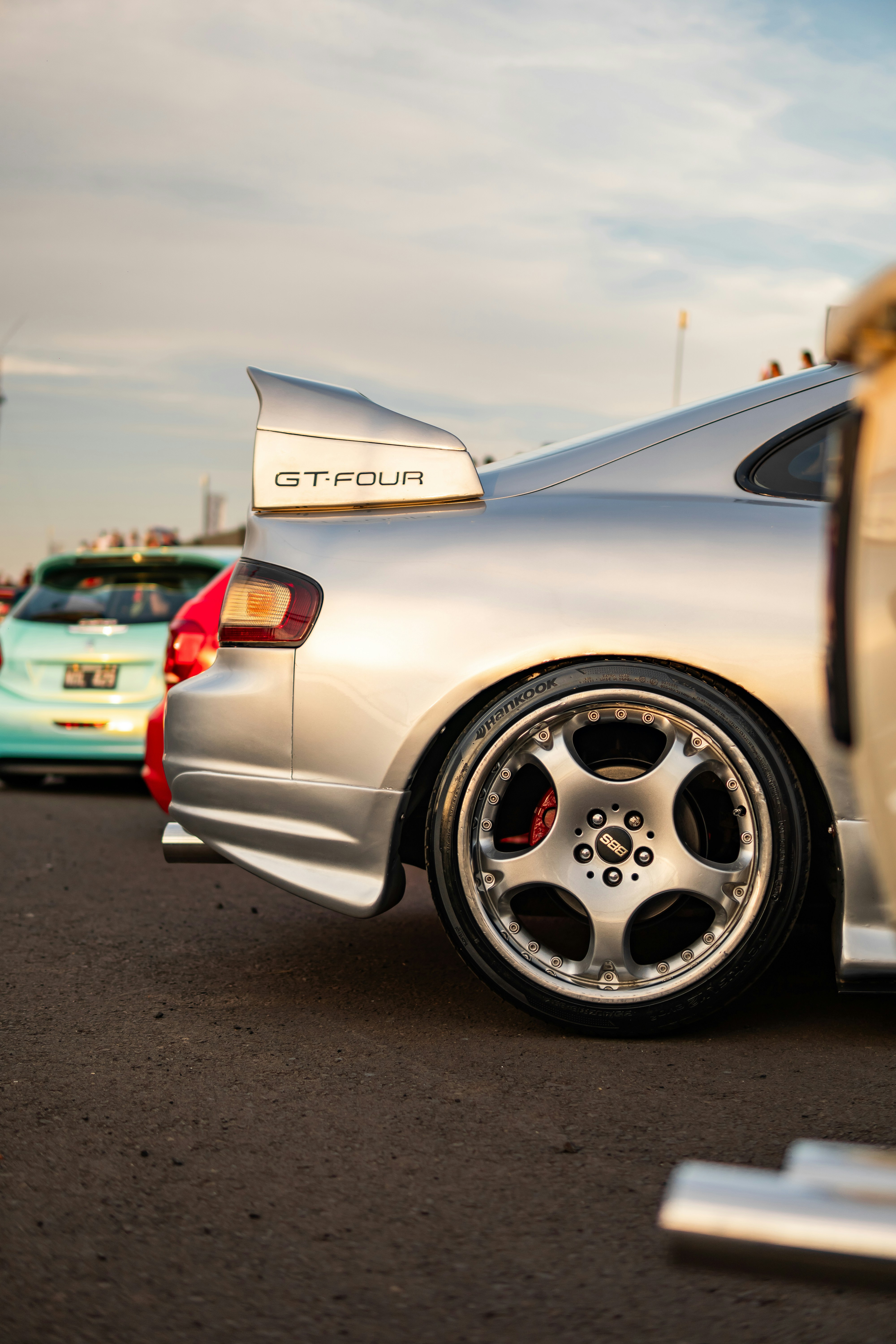 A Silver GT:FOUR Wing and Wheel in Focus at Sunset Photo Op
