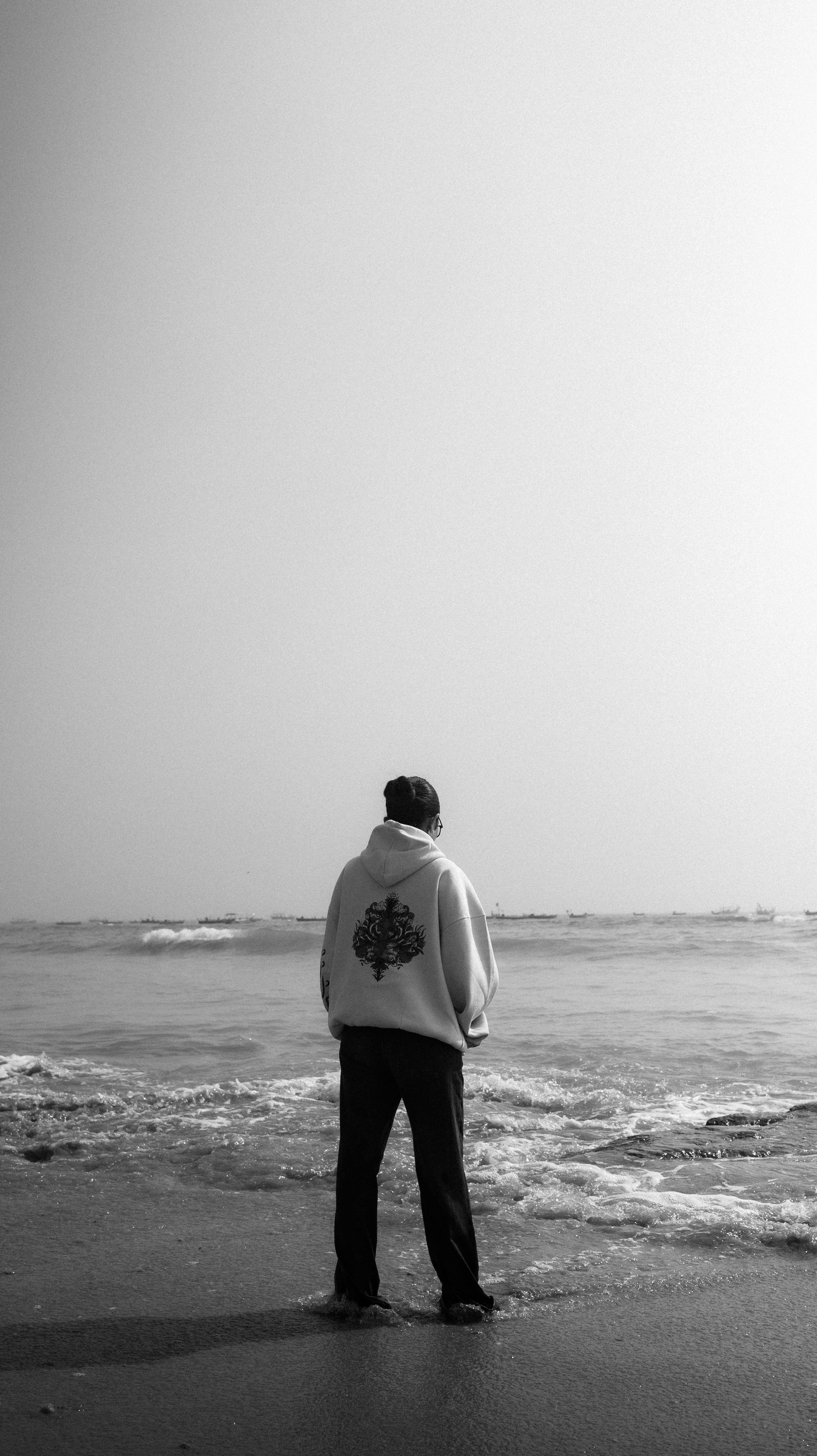 Lonely Shoreline: A Voyager in Hoodie Stares at an Endless Sea