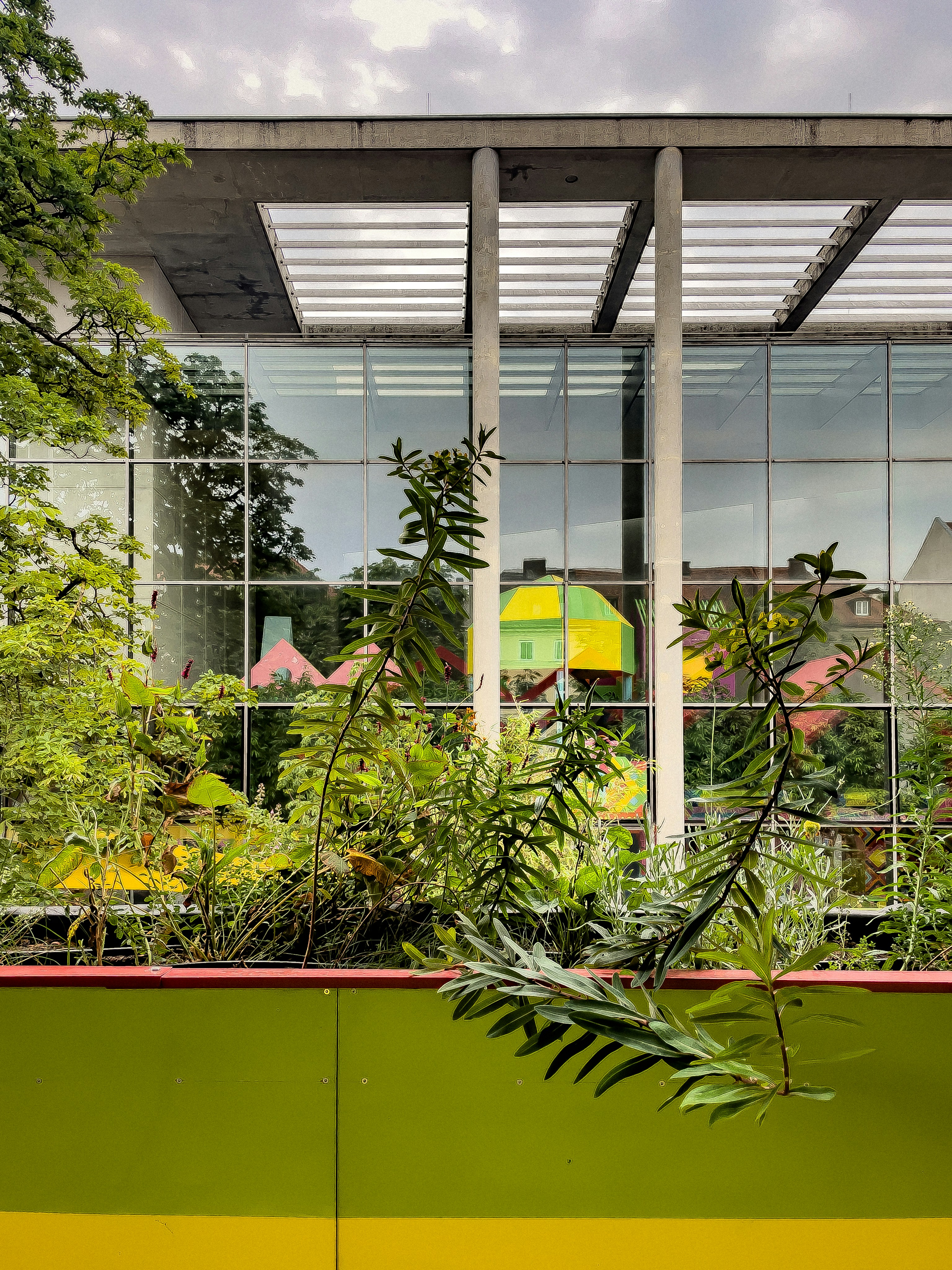 Vertical Garden Framed by Modern Glass: Plants Meet a Colorful Facade