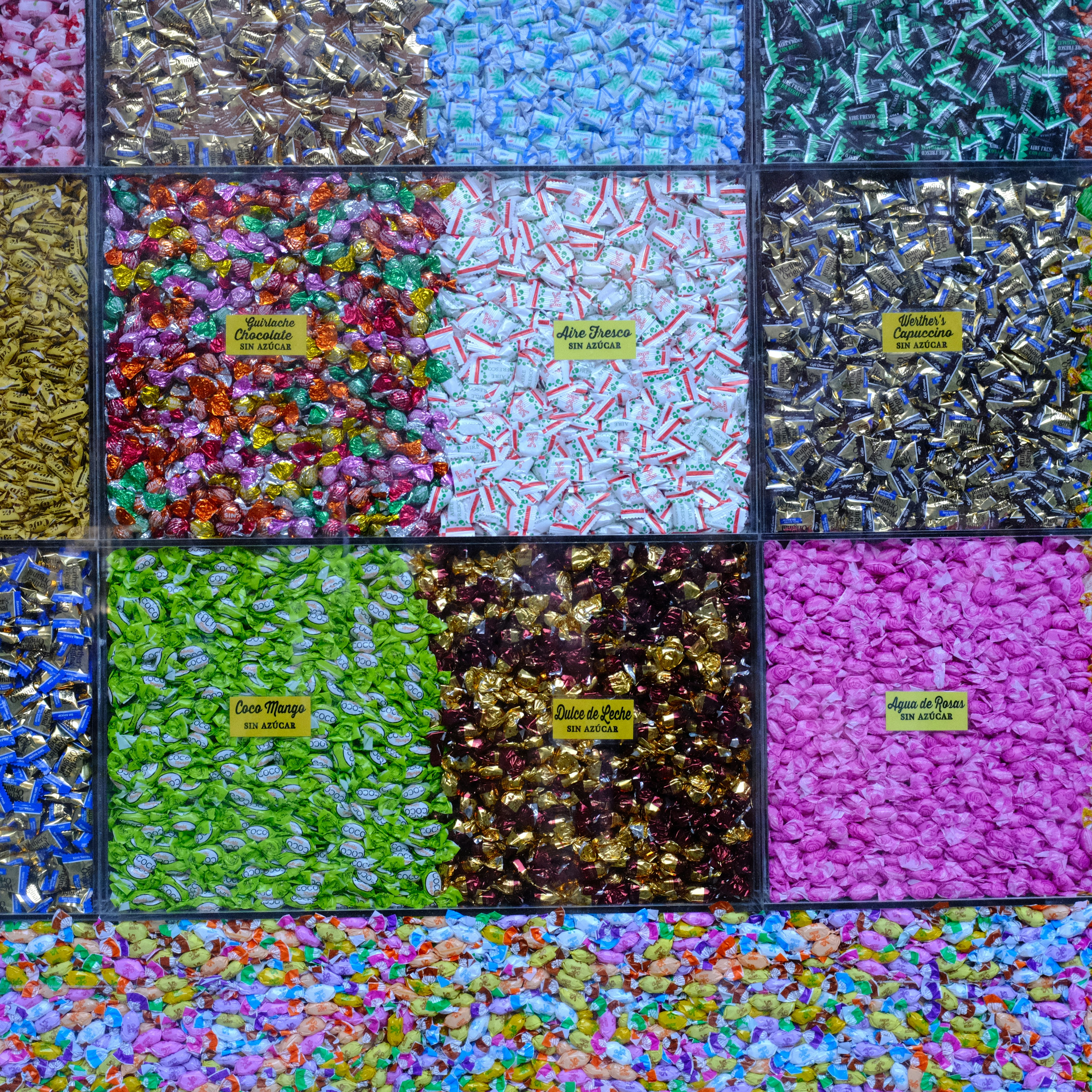 Velvet Grid of Confections: A Rainbow Mosaic of Wrapped Candies