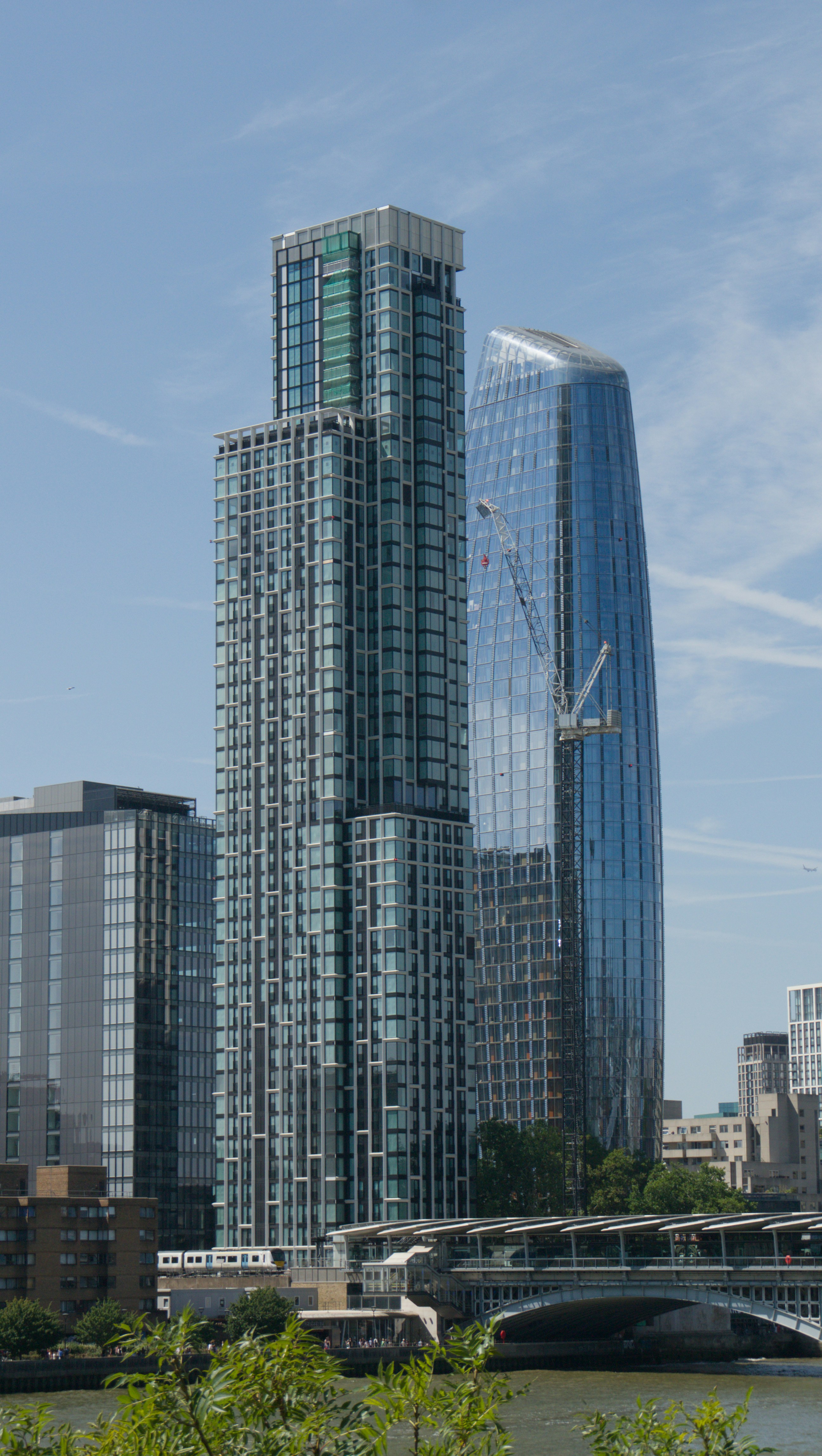 Twin Towers Over the Thames: Glass and Crane against a Clear Sky