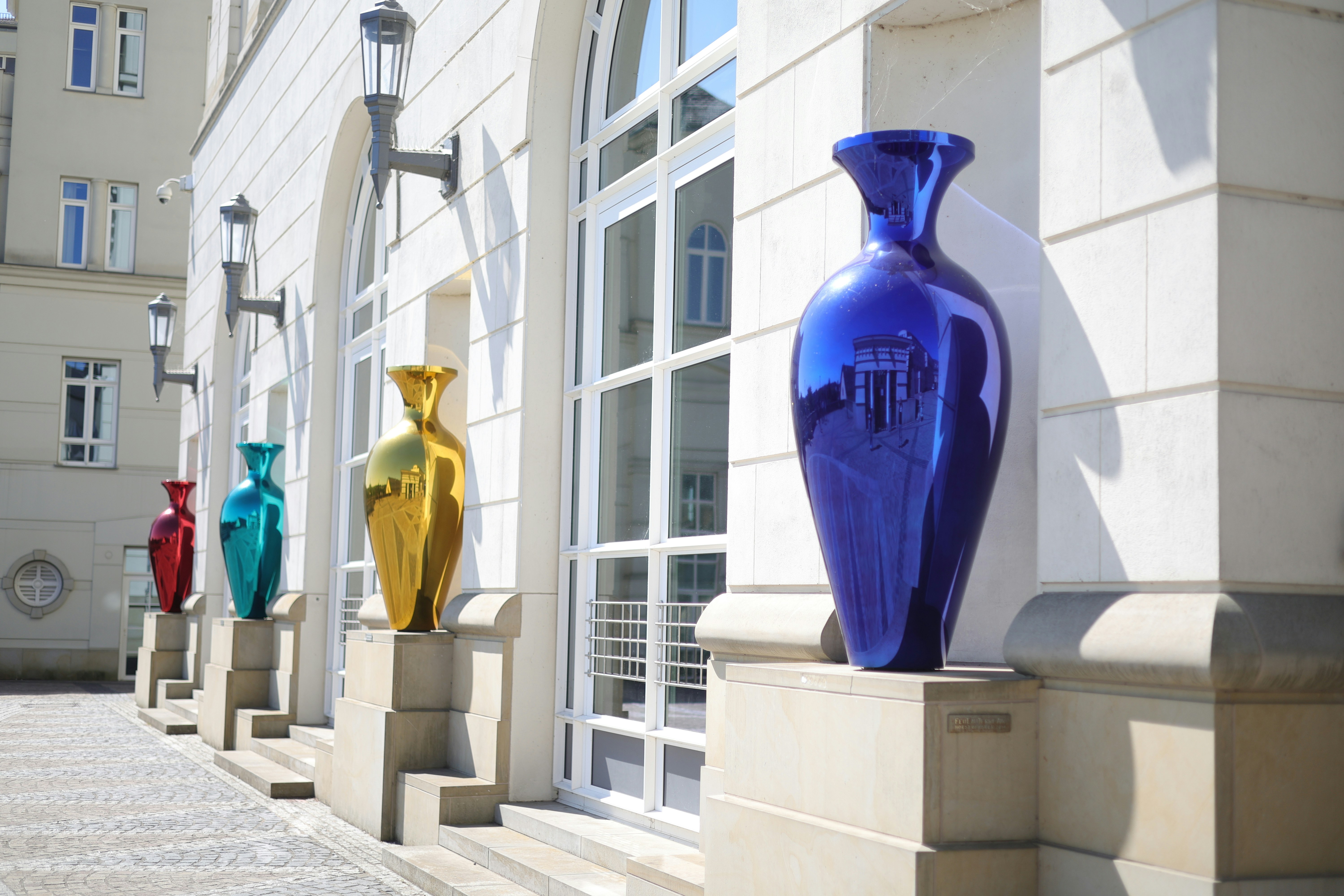 Colorful Vases line the courthouse stairs under arched windows
