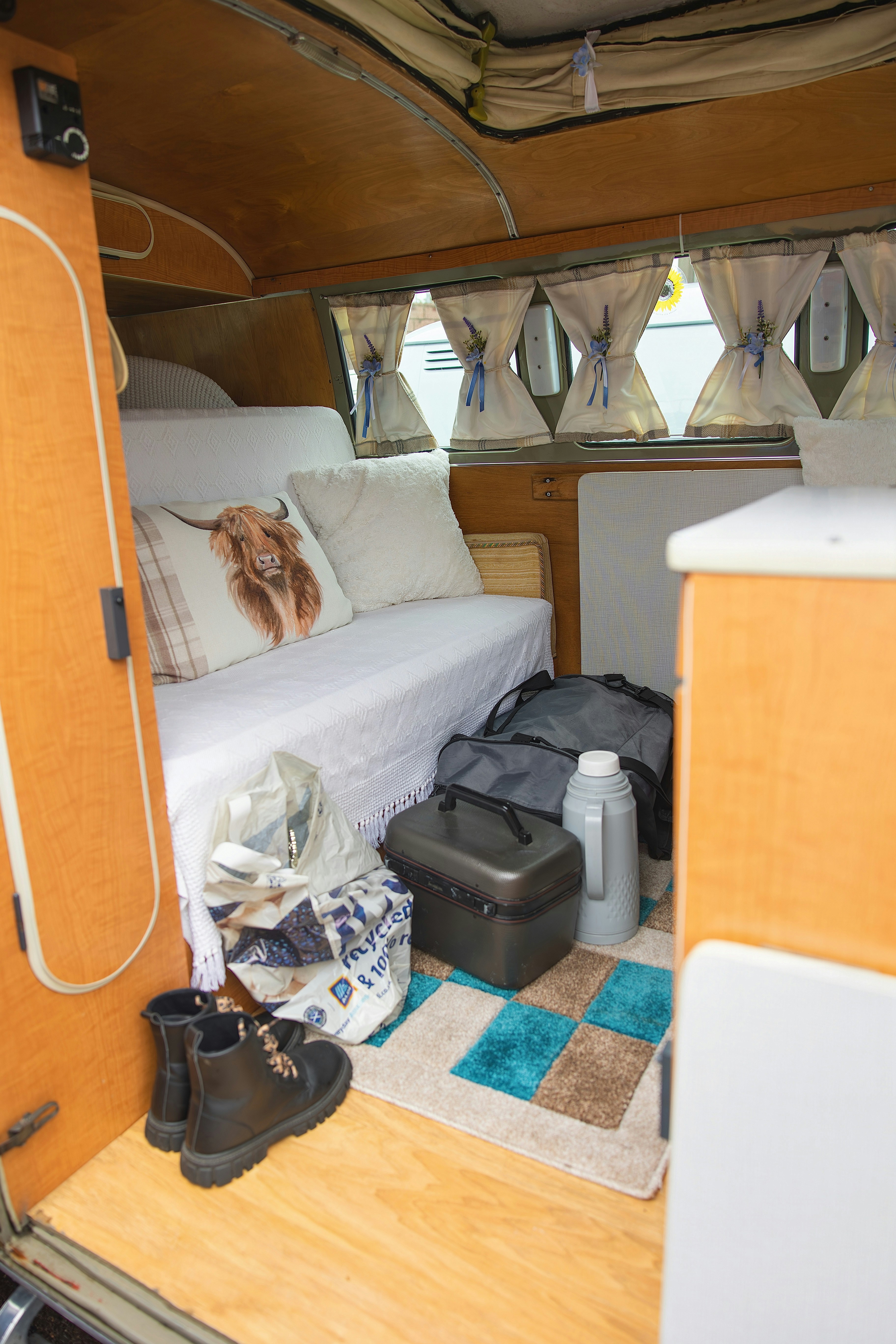 Cozy Camper Interior: Cushions, Boots, and Gear Nestled by a Windowed Lounge