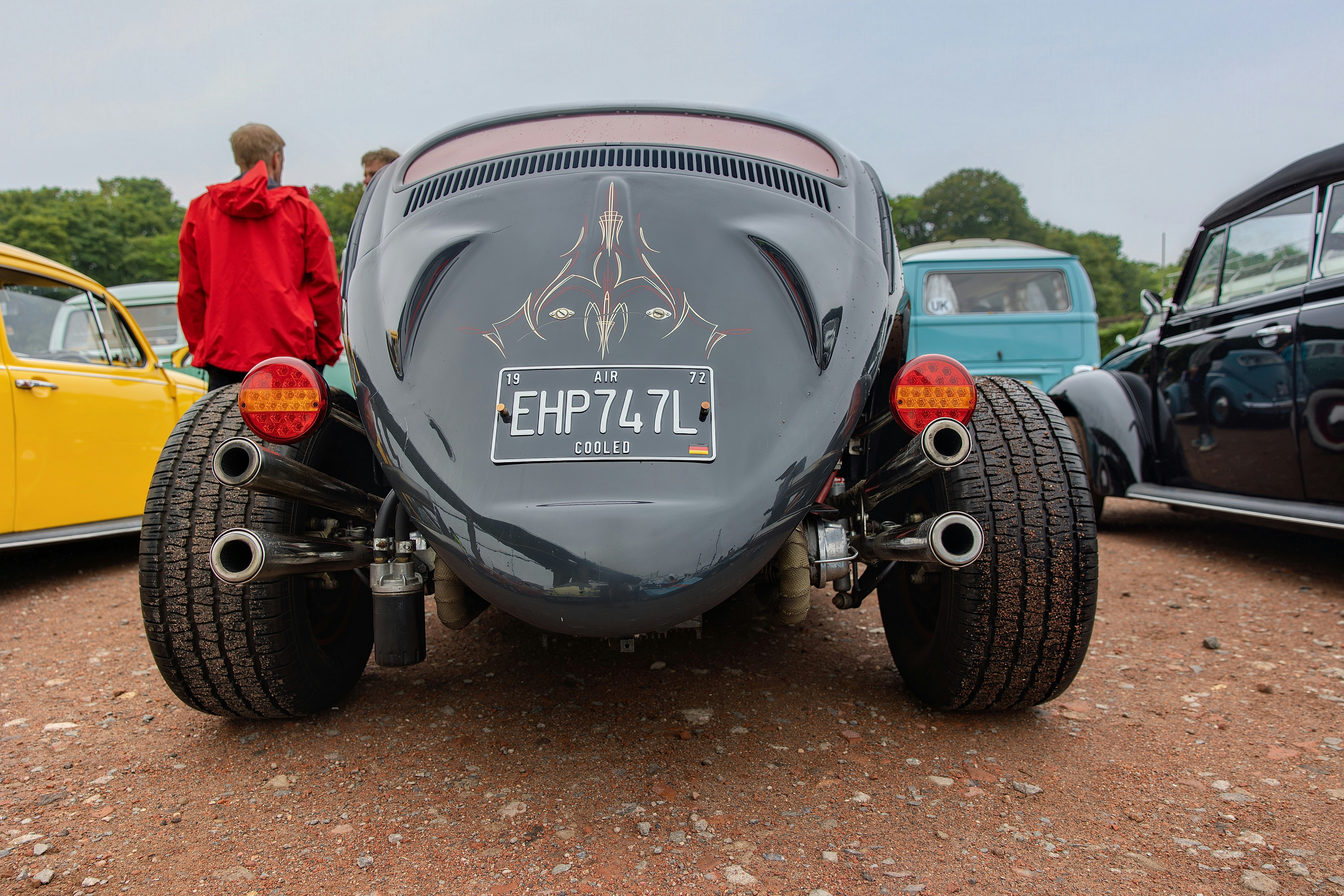 Taillights and Chrome Cumuli: A row of vintage beetles from the rear