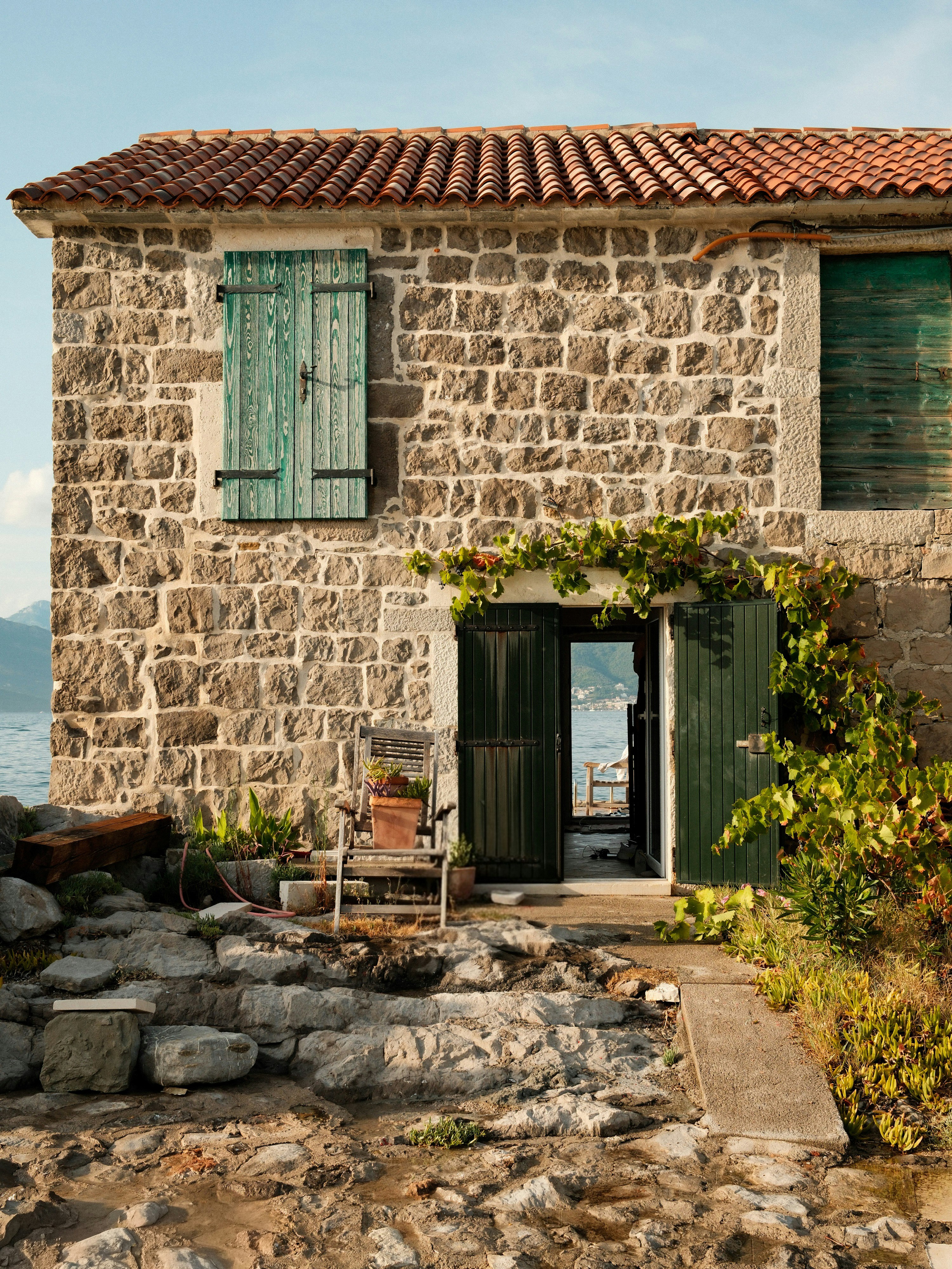 Stone Seaside Retreat Through Green Doors