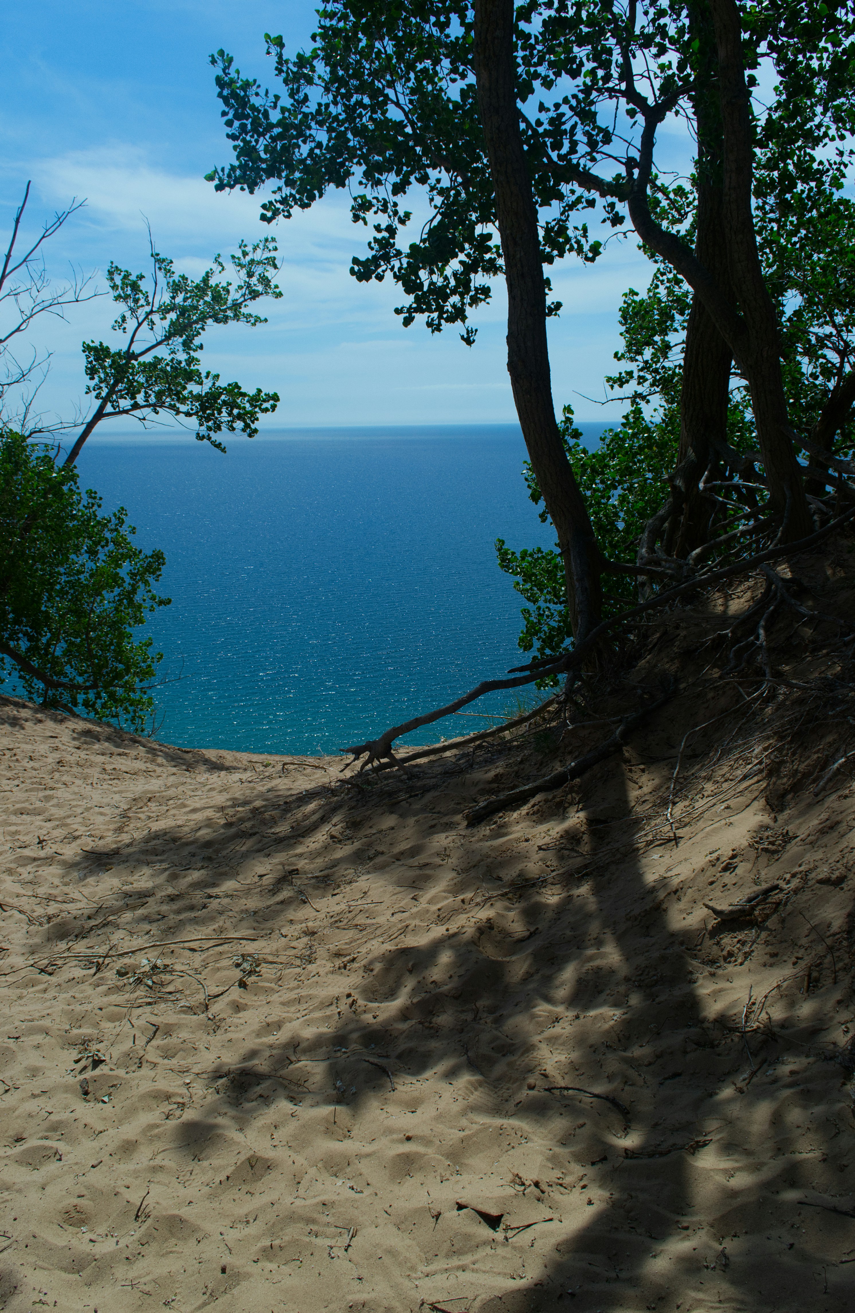 Coastal Cliff Edge: Shadowed Sand and Ocean Span