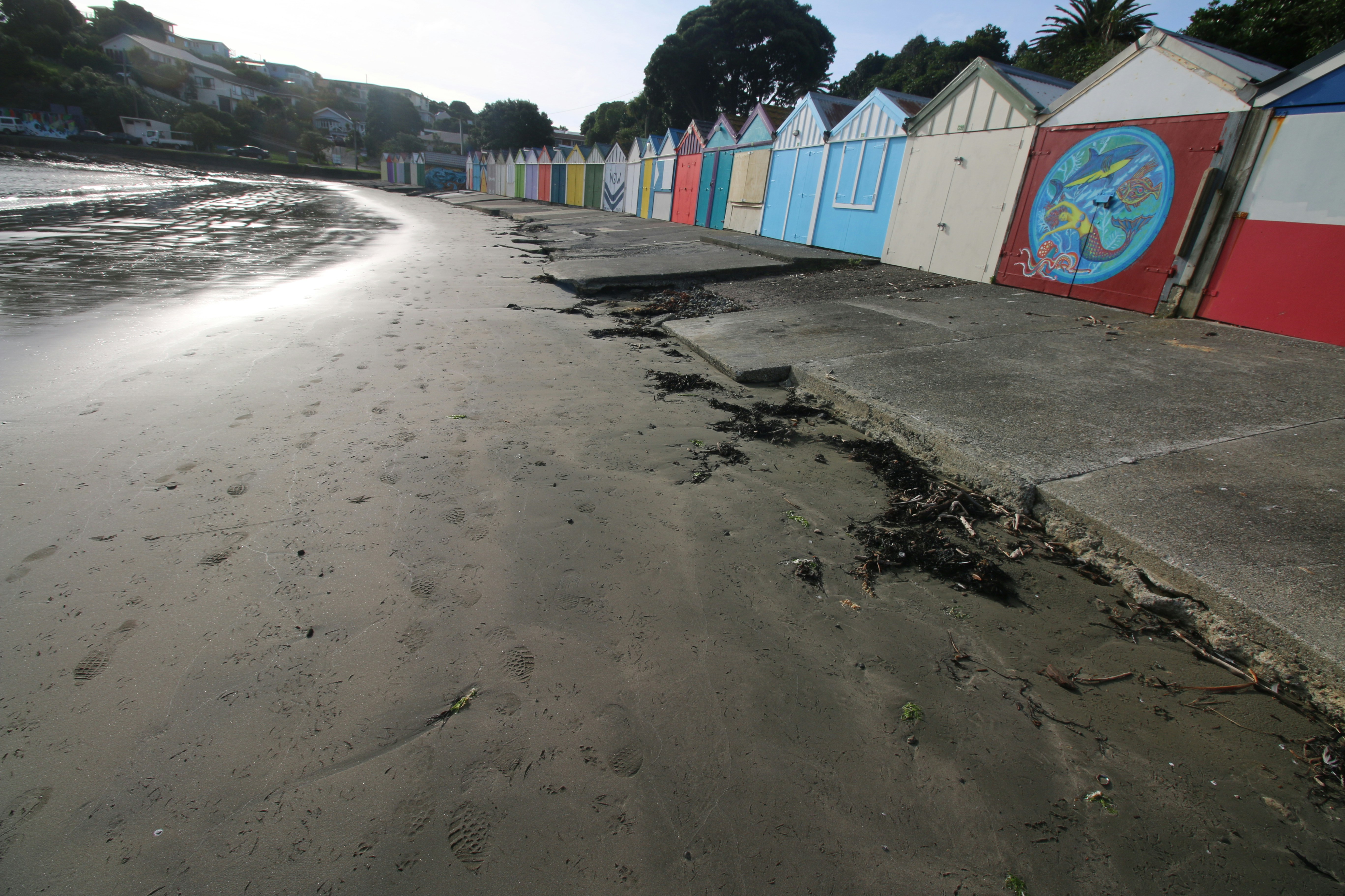 Colorful Beachside Row of Huts Along Cracked Shoreline