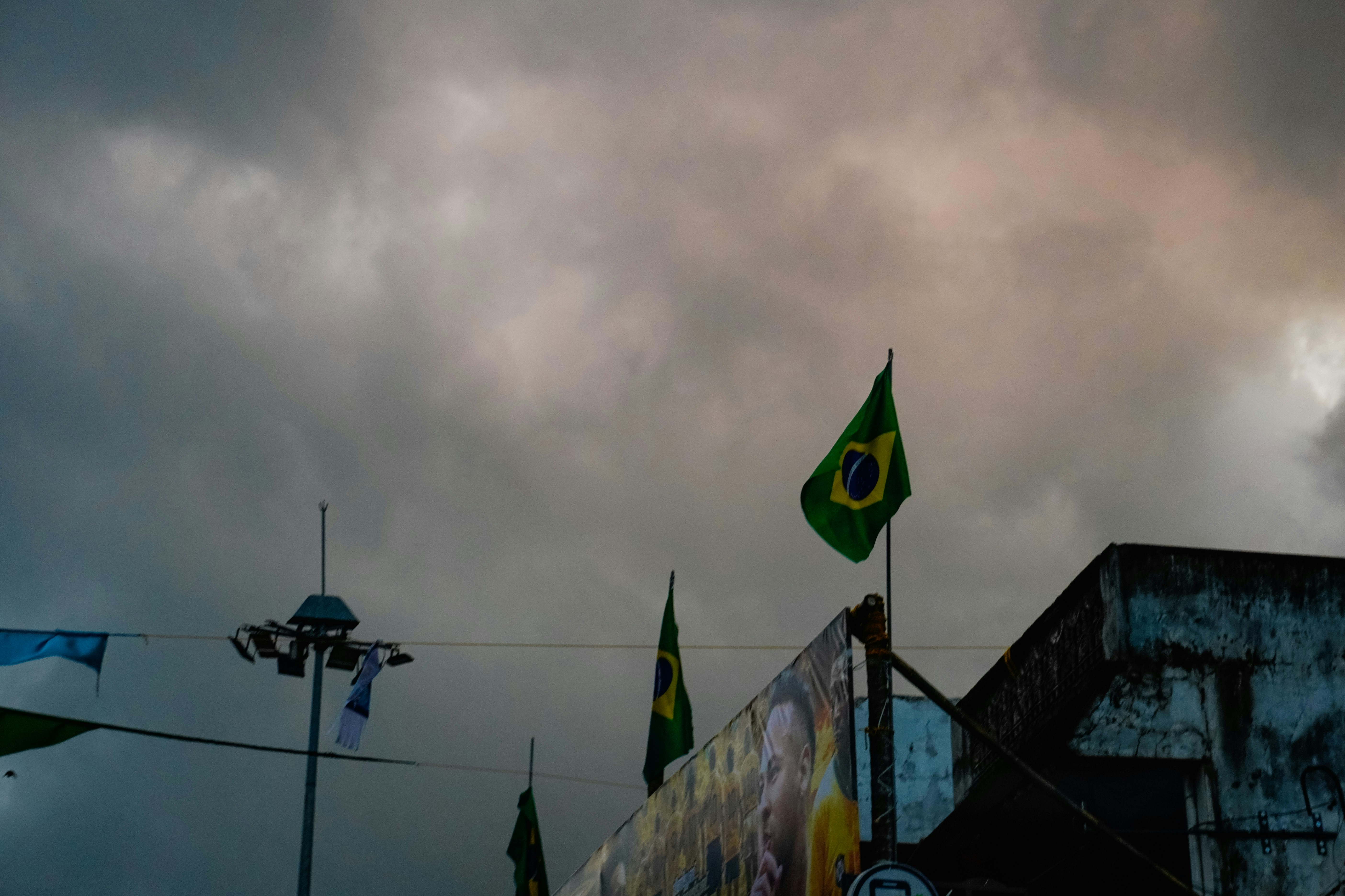 Flagged skyline: Brazil flags over a weathered rooftop at dusk