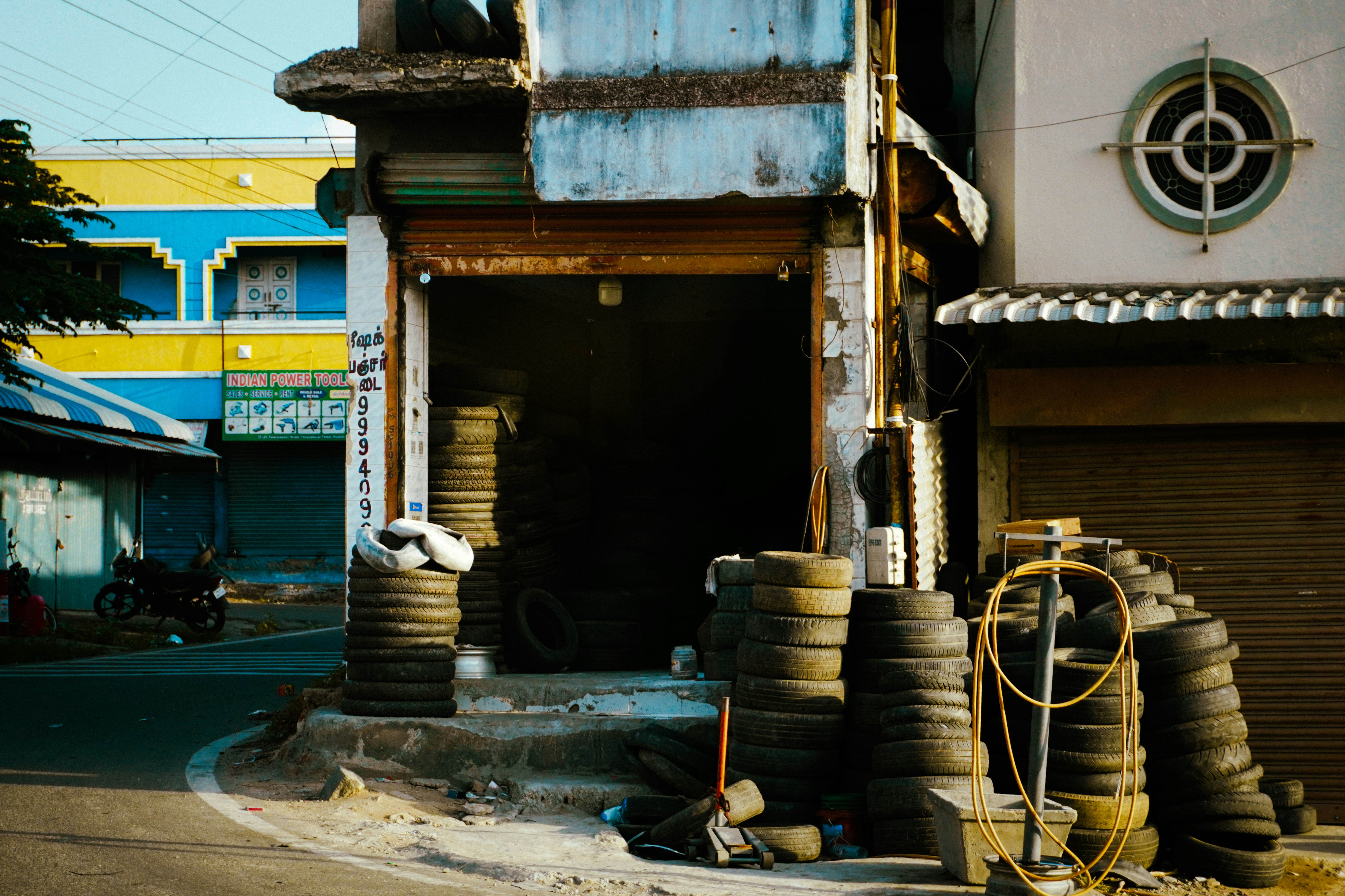 Abandoned Tire Shop at the Corner, Sunlit Street
