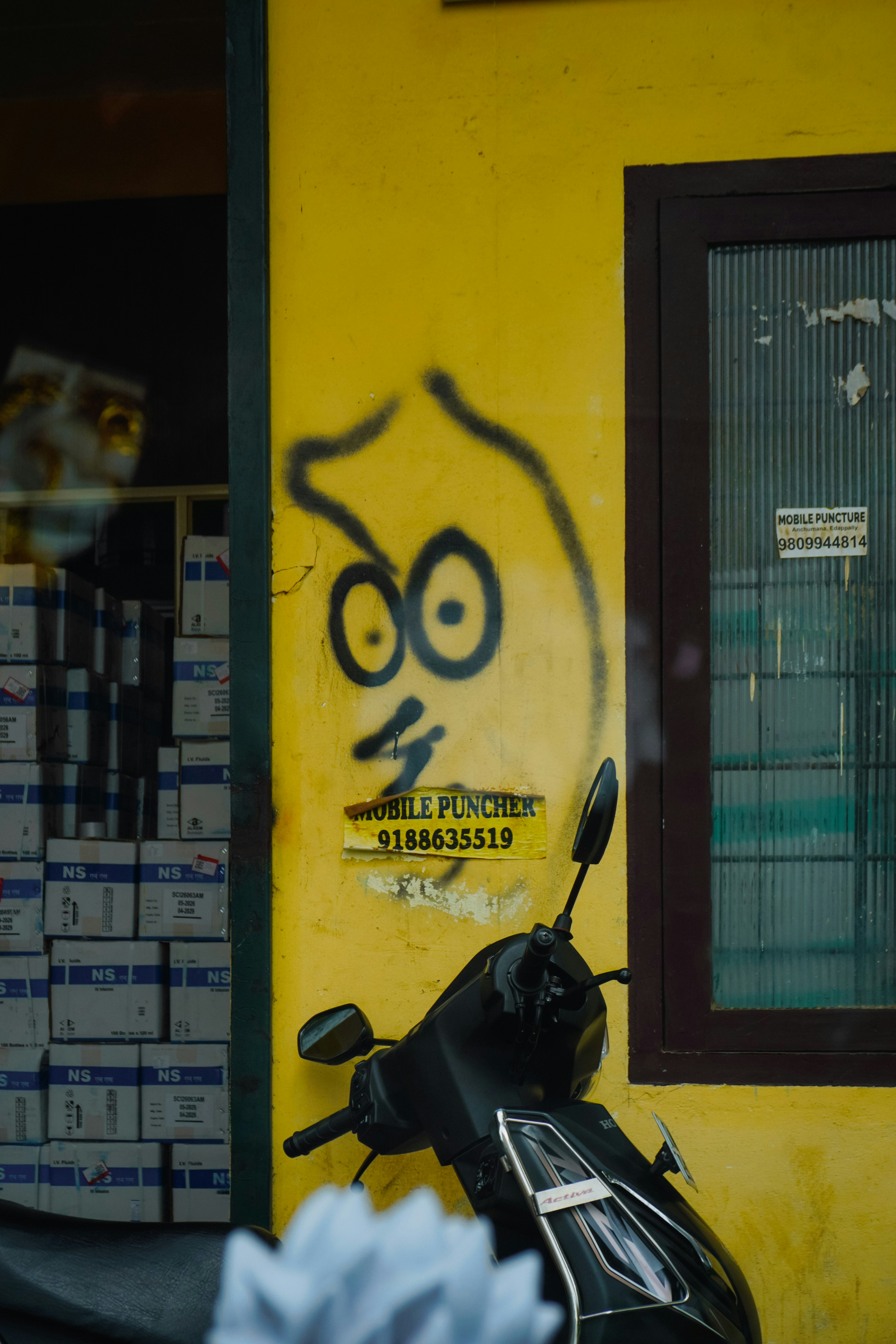 Yellow Facade with Graffiti and Scooter at the Threshold of a Workshop