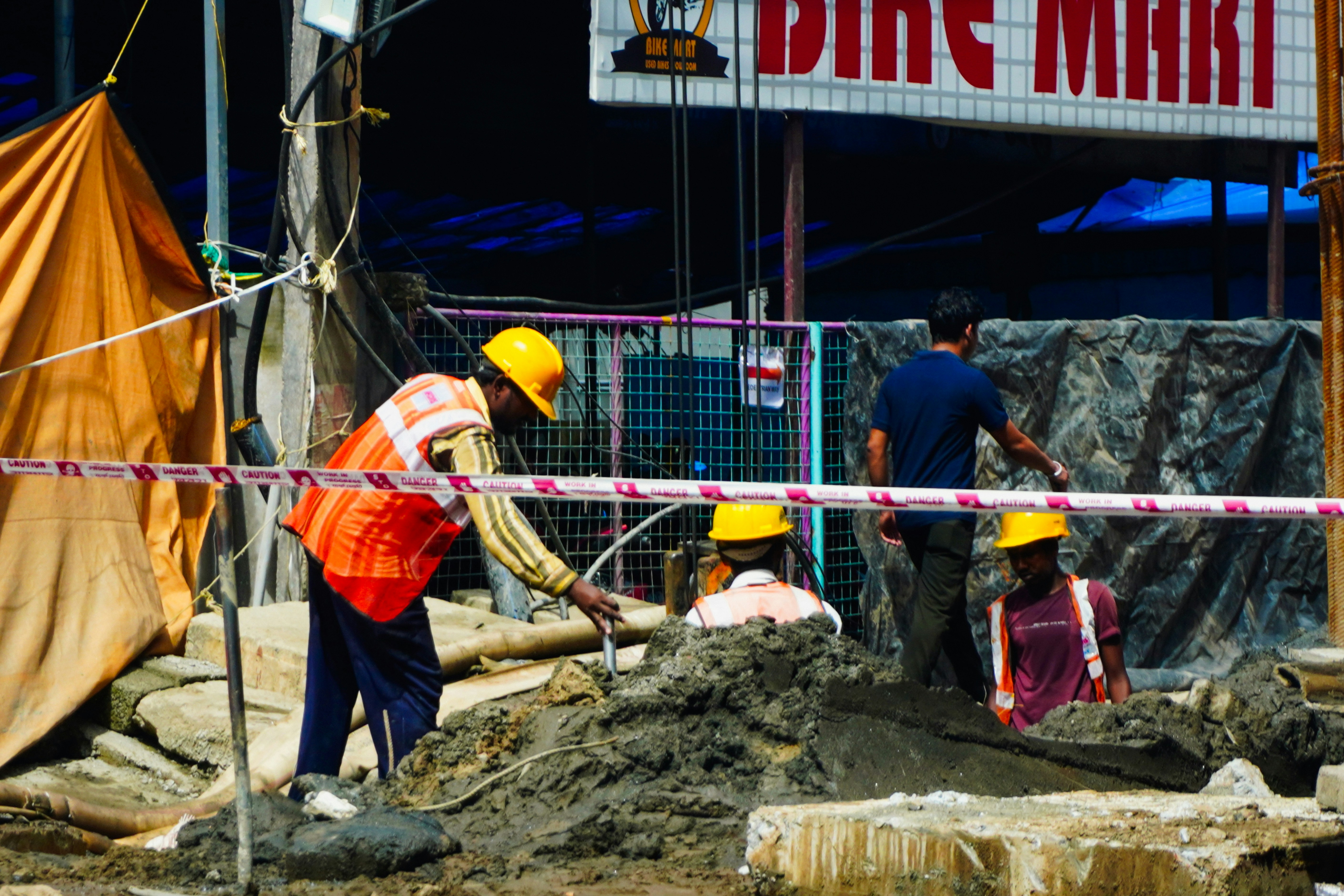 Hard Hats, Hard Ground: Construction Crew at Work Beneath a Banner