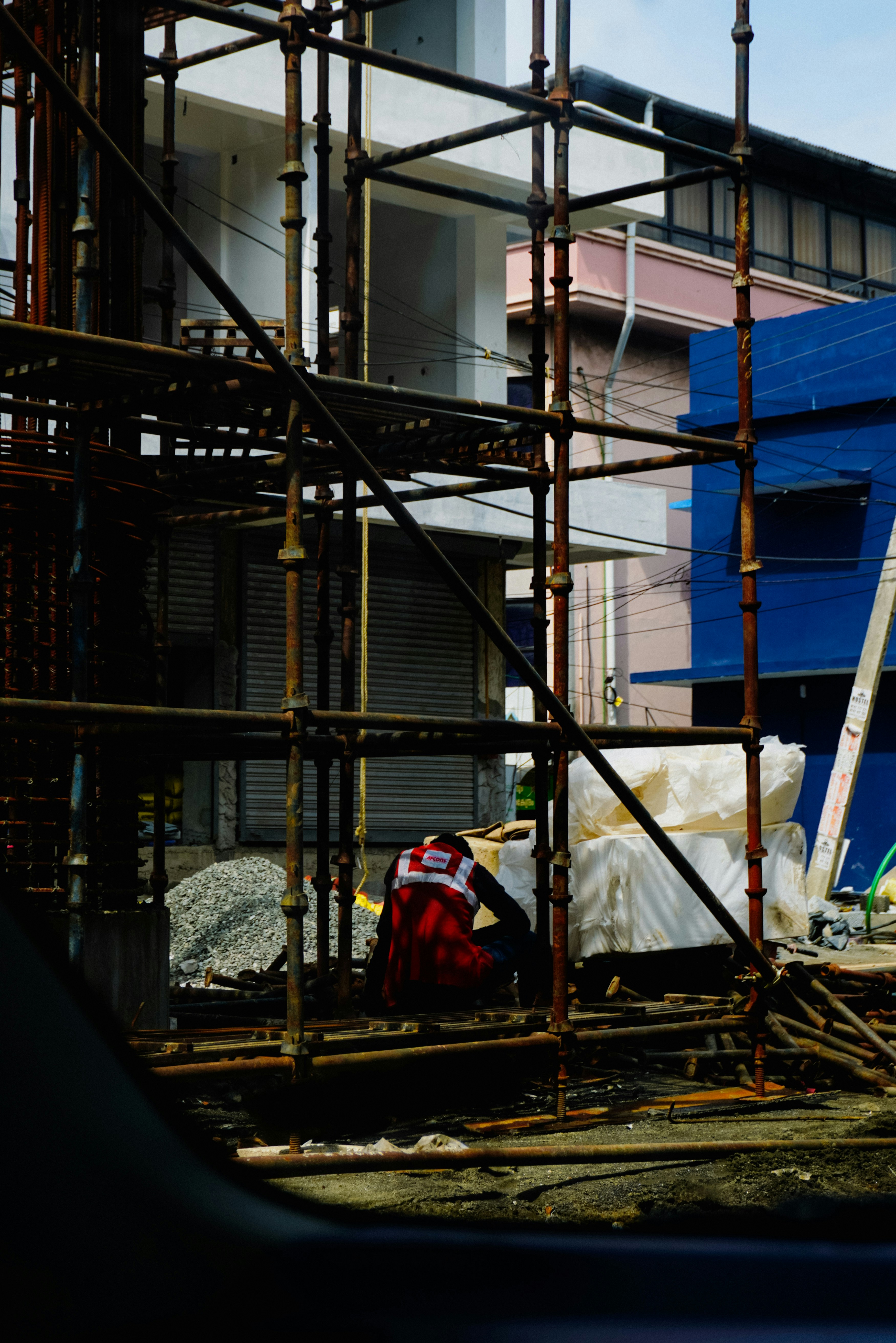 Hidden Worker Amid Crisscrossing Scaffolding at Dawn of a Construction Site