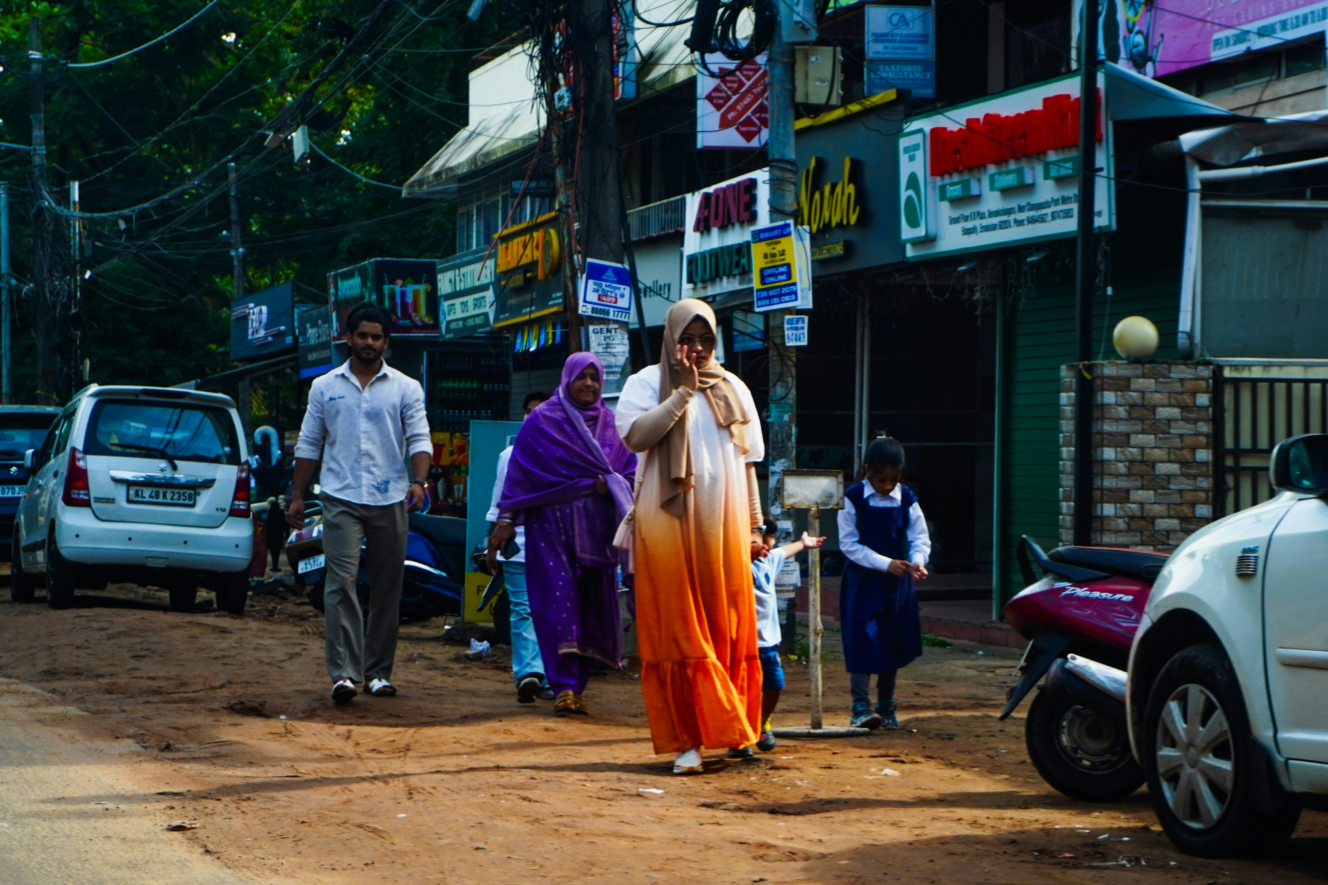 Street Scene in Turmeric Light: A Woman in Orange Draped Saree Leading the Way
