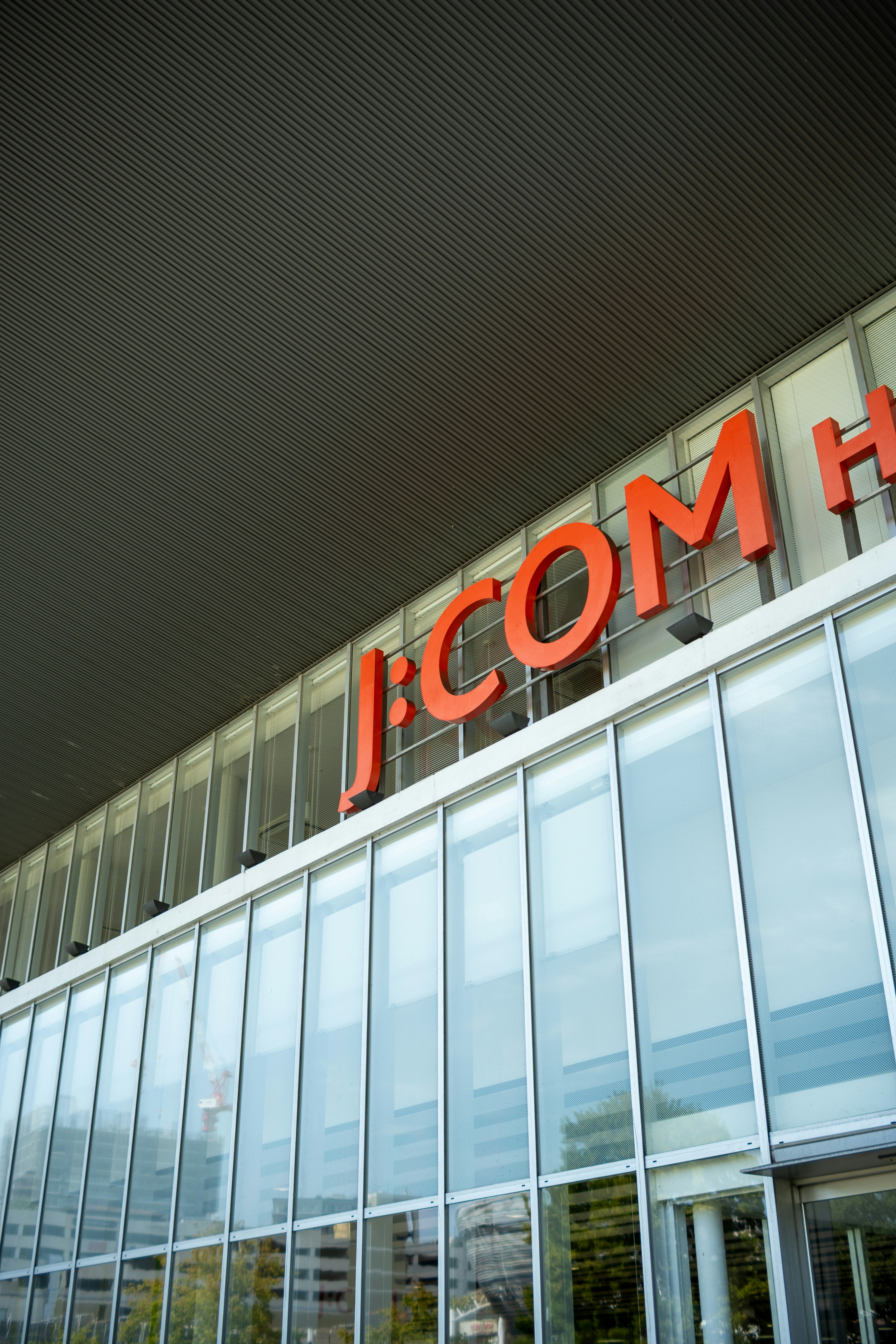 Bold red letters anchor a modern glass façade storefront