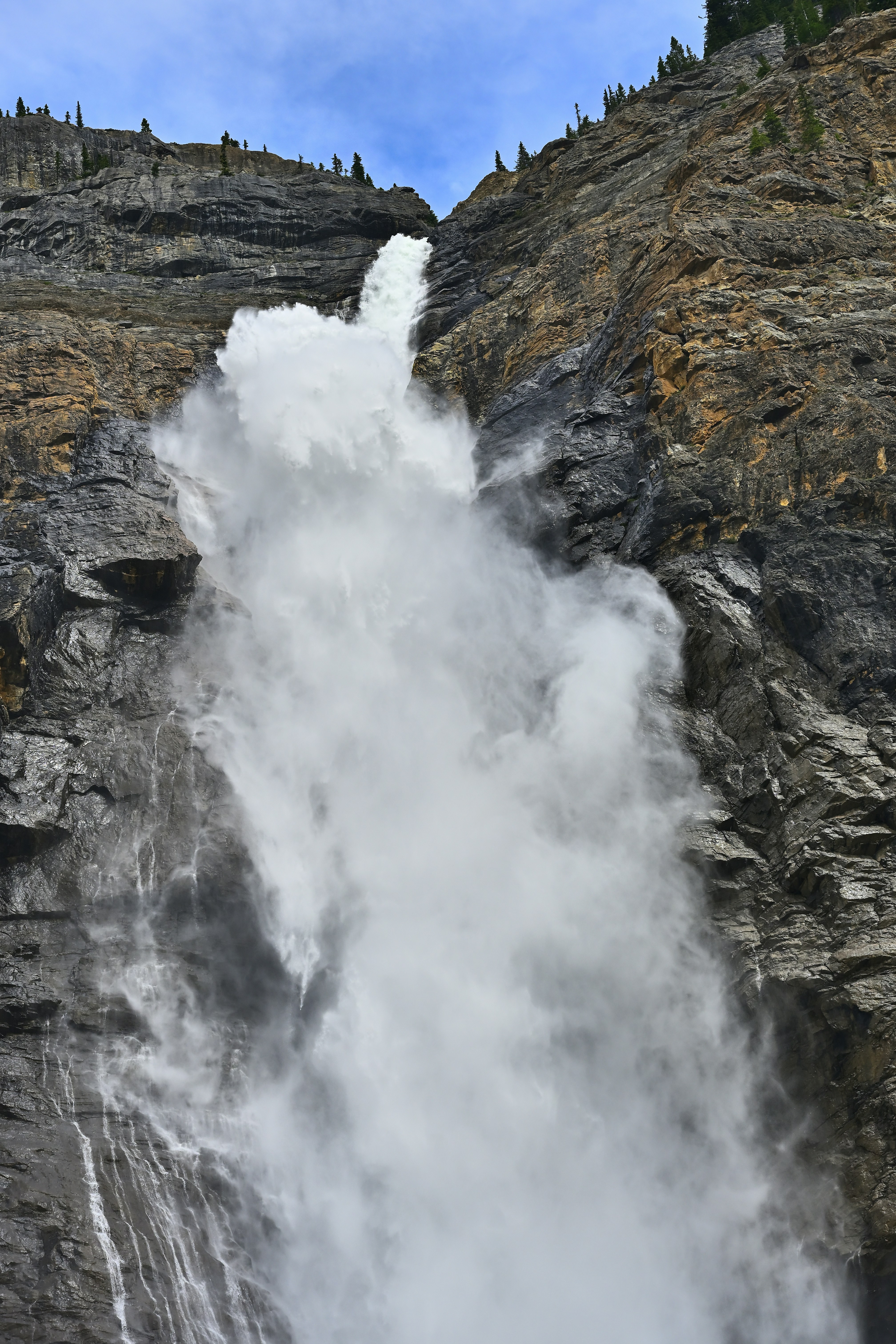 Cascading Curtain: A Mighty Fall Between Weathered Cliffs