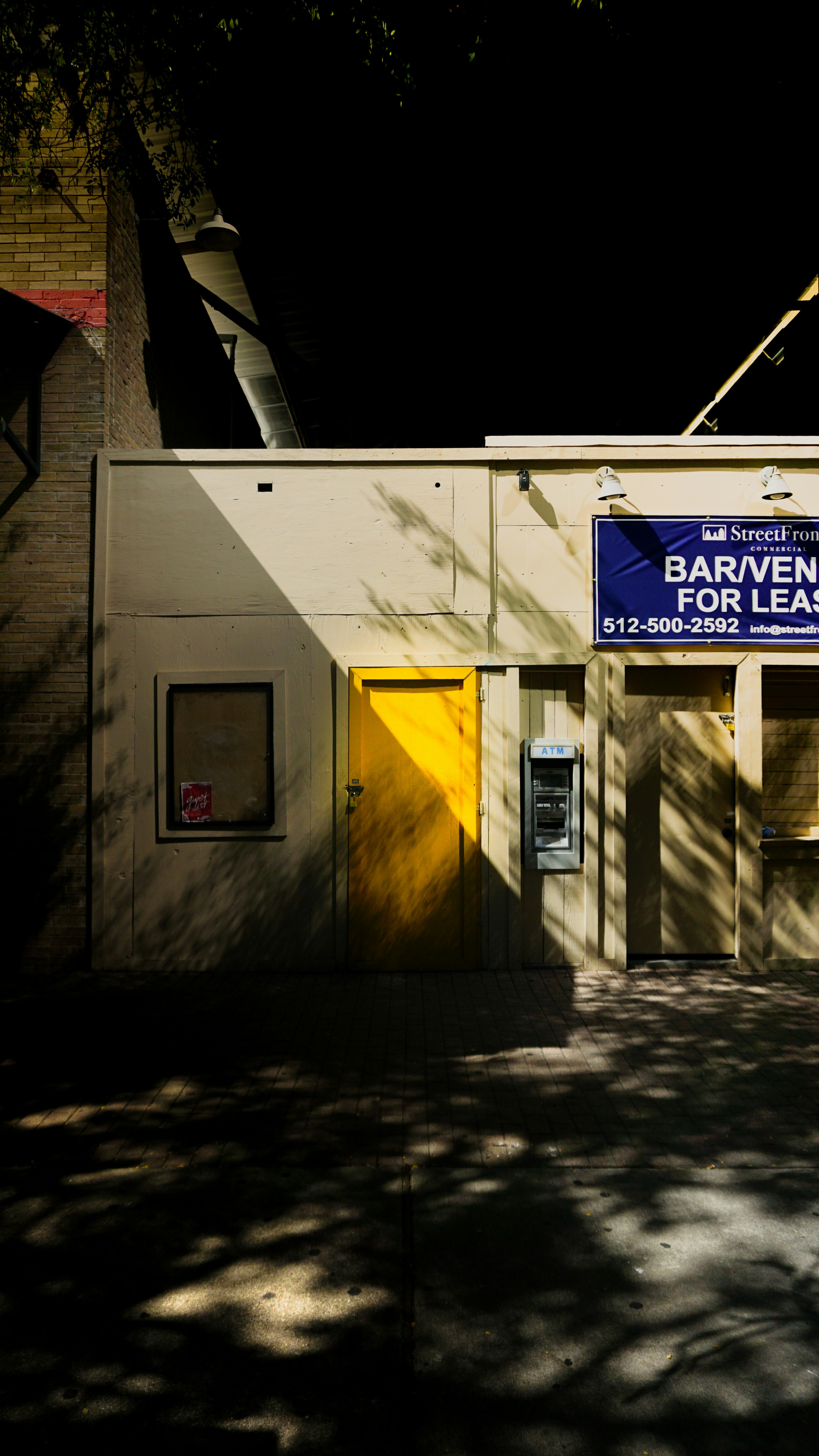 Yellow Door under Shadowed Facade on an Urban Street