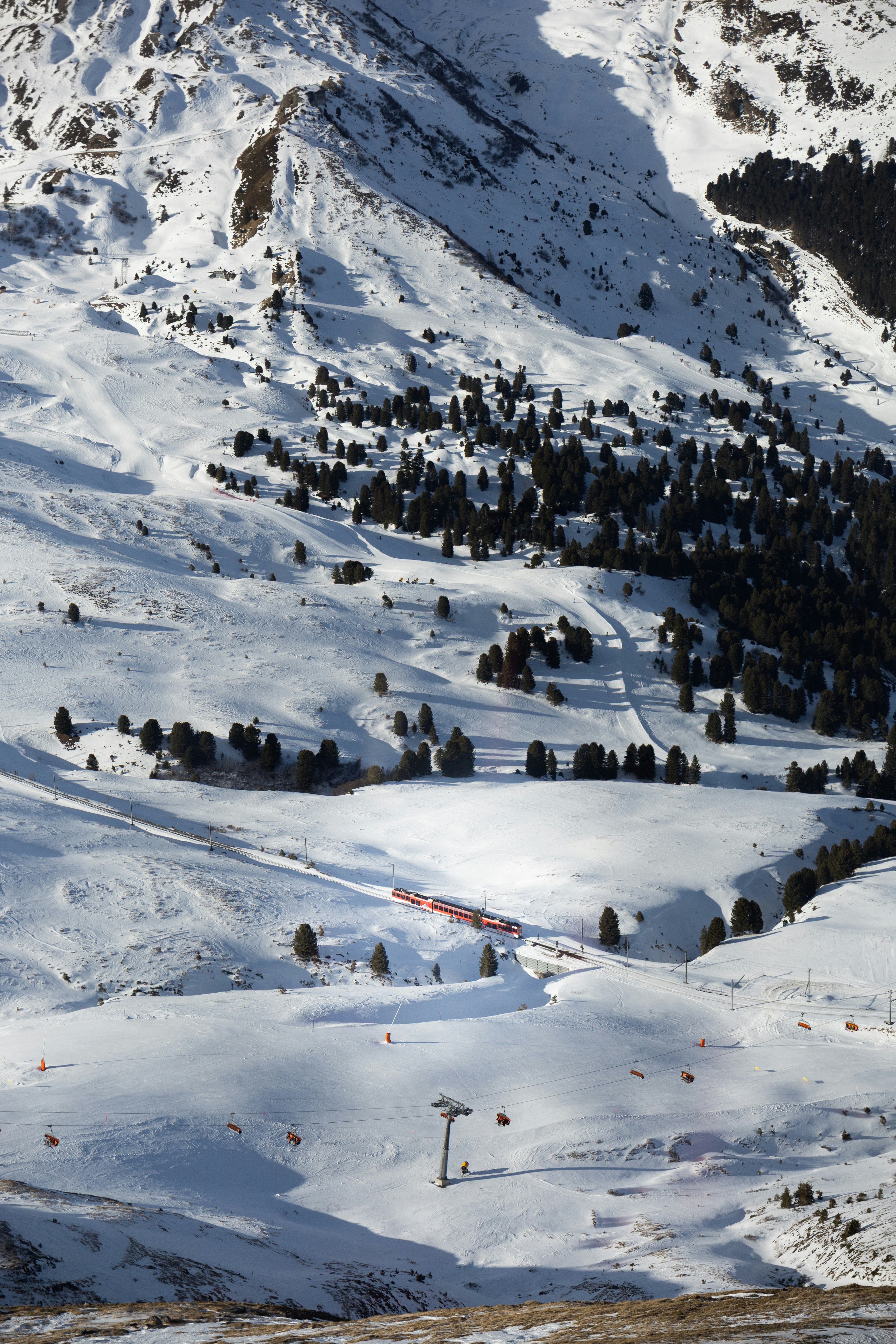Snowbound Valley Express: The Red Train Wends Through Alpine Silence