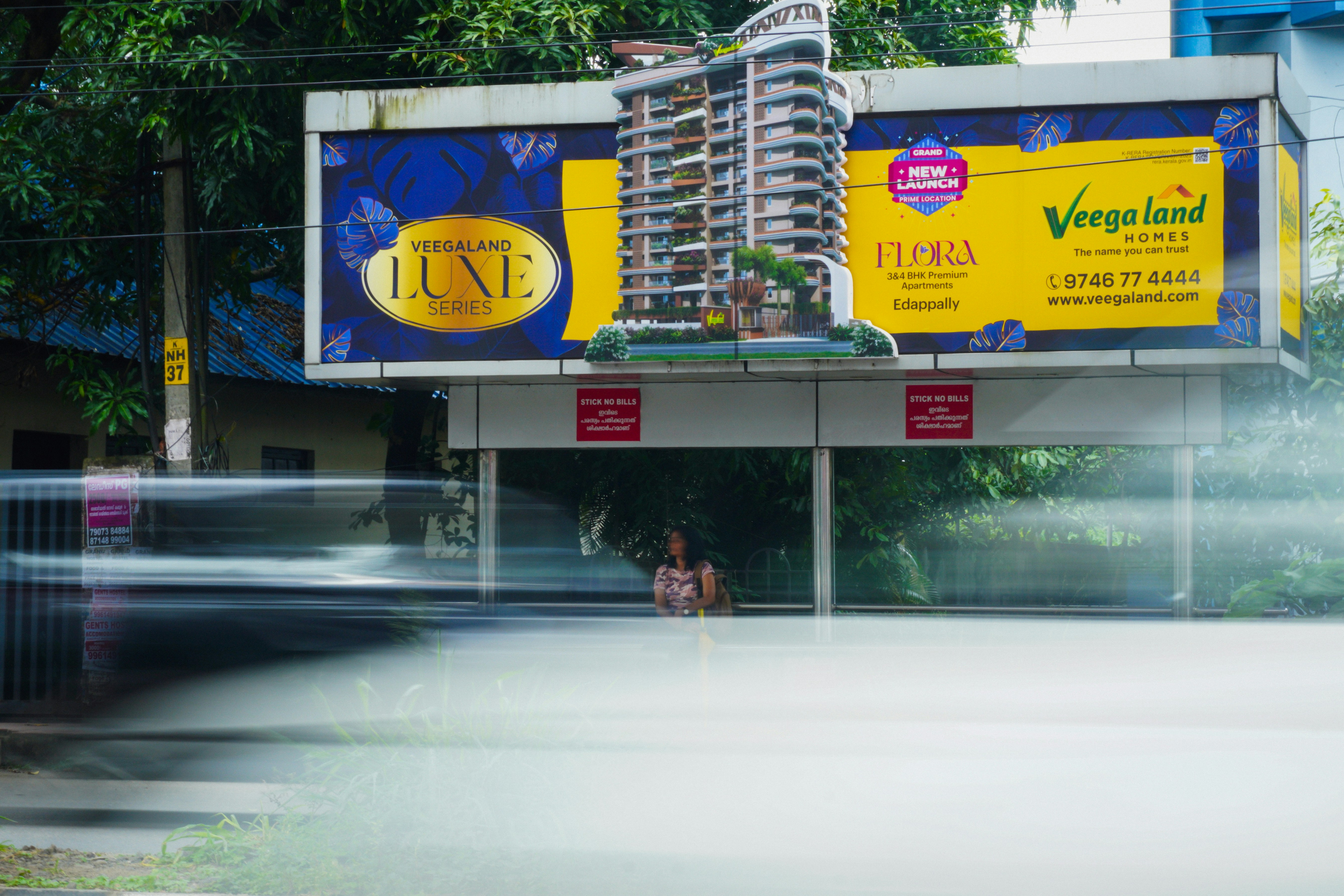 Billboarded Oasis: A Glimpse of City Life Beneath the Moving Veil