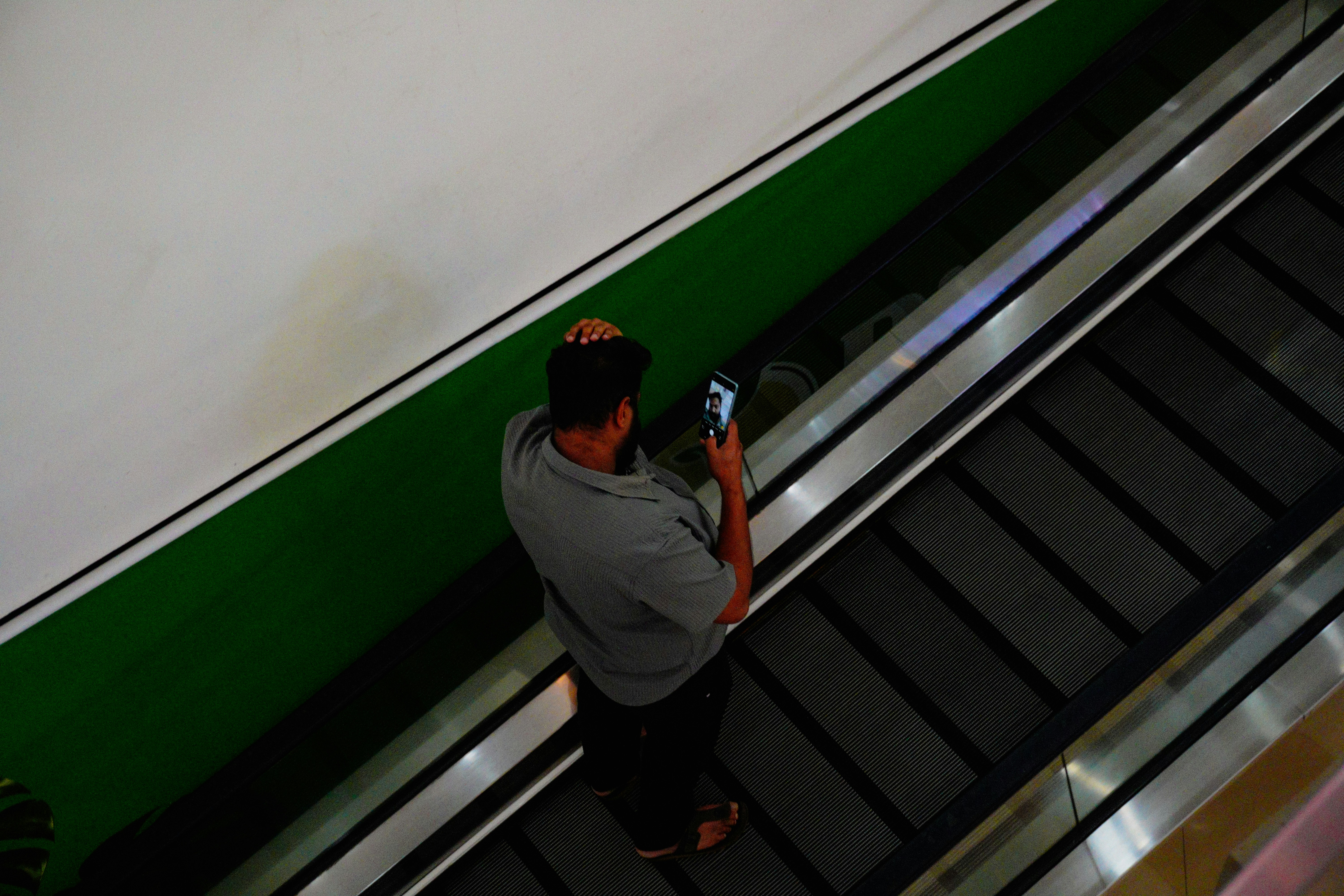 Tap on the Move: A commuterCaptures a Moment on the Escalator
