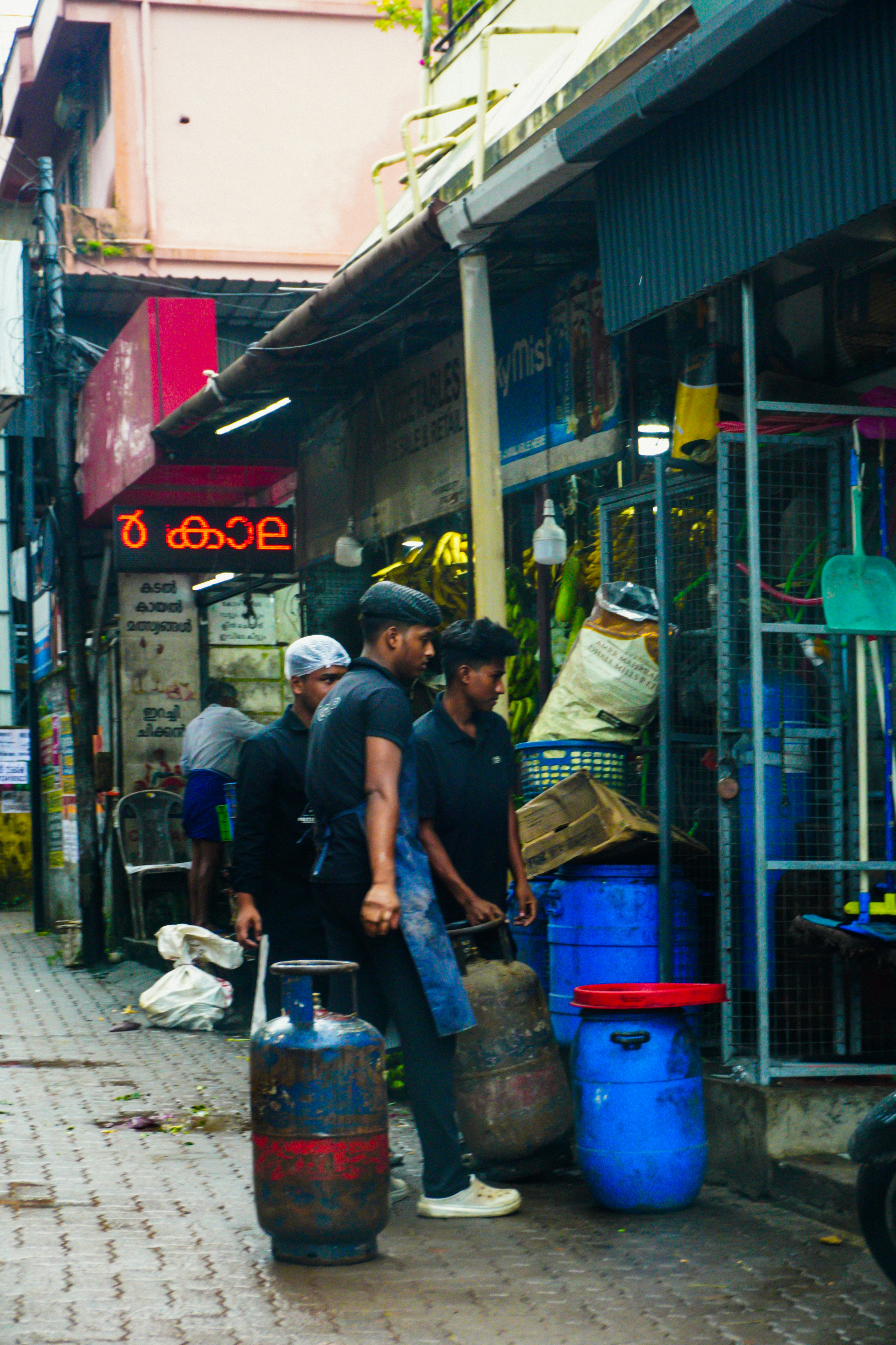 Market Crew in Focus: Three Timid Men Across a Bustling Alley
