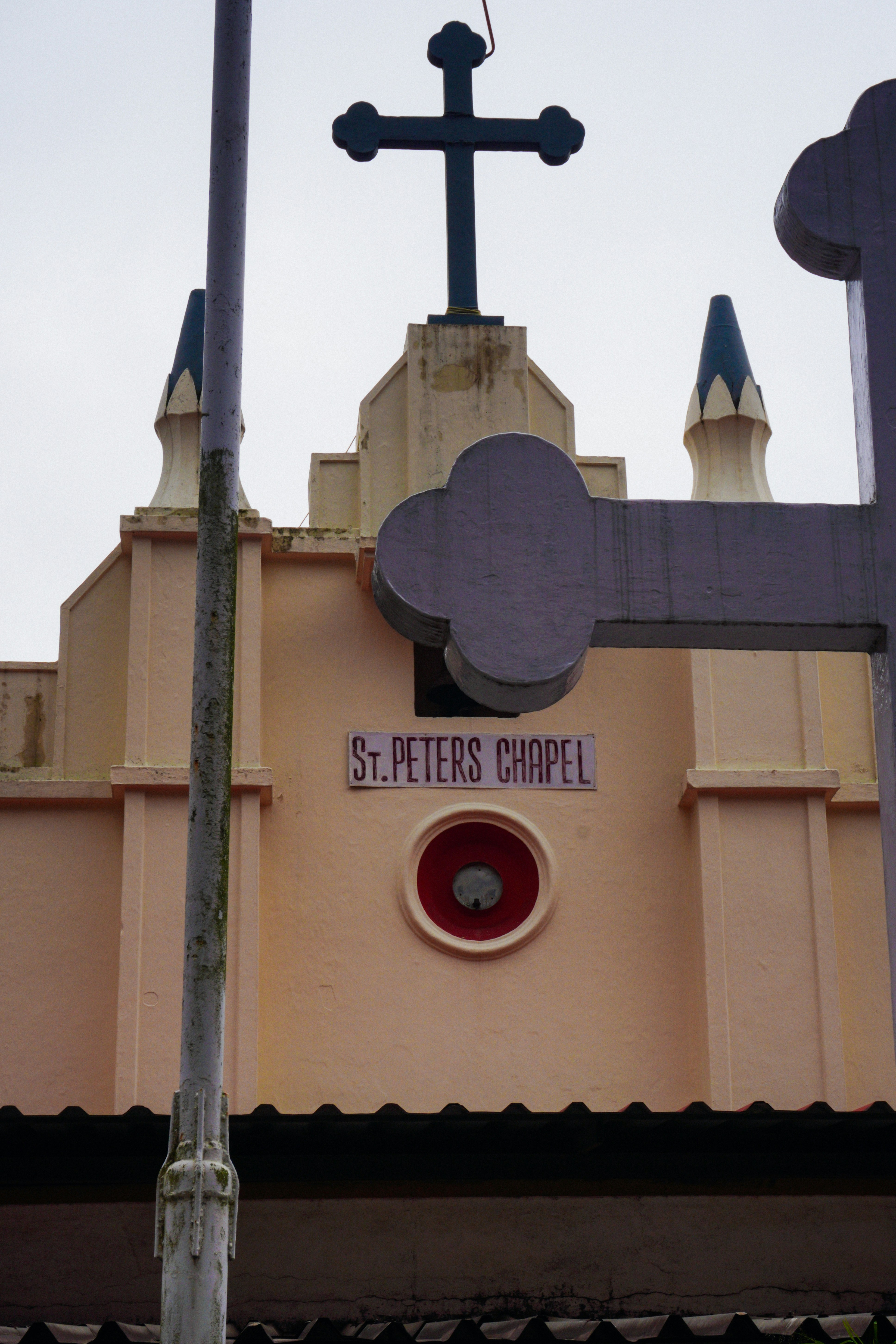 Cross and Chapel: A Quiet Facade Under a Stately Sky