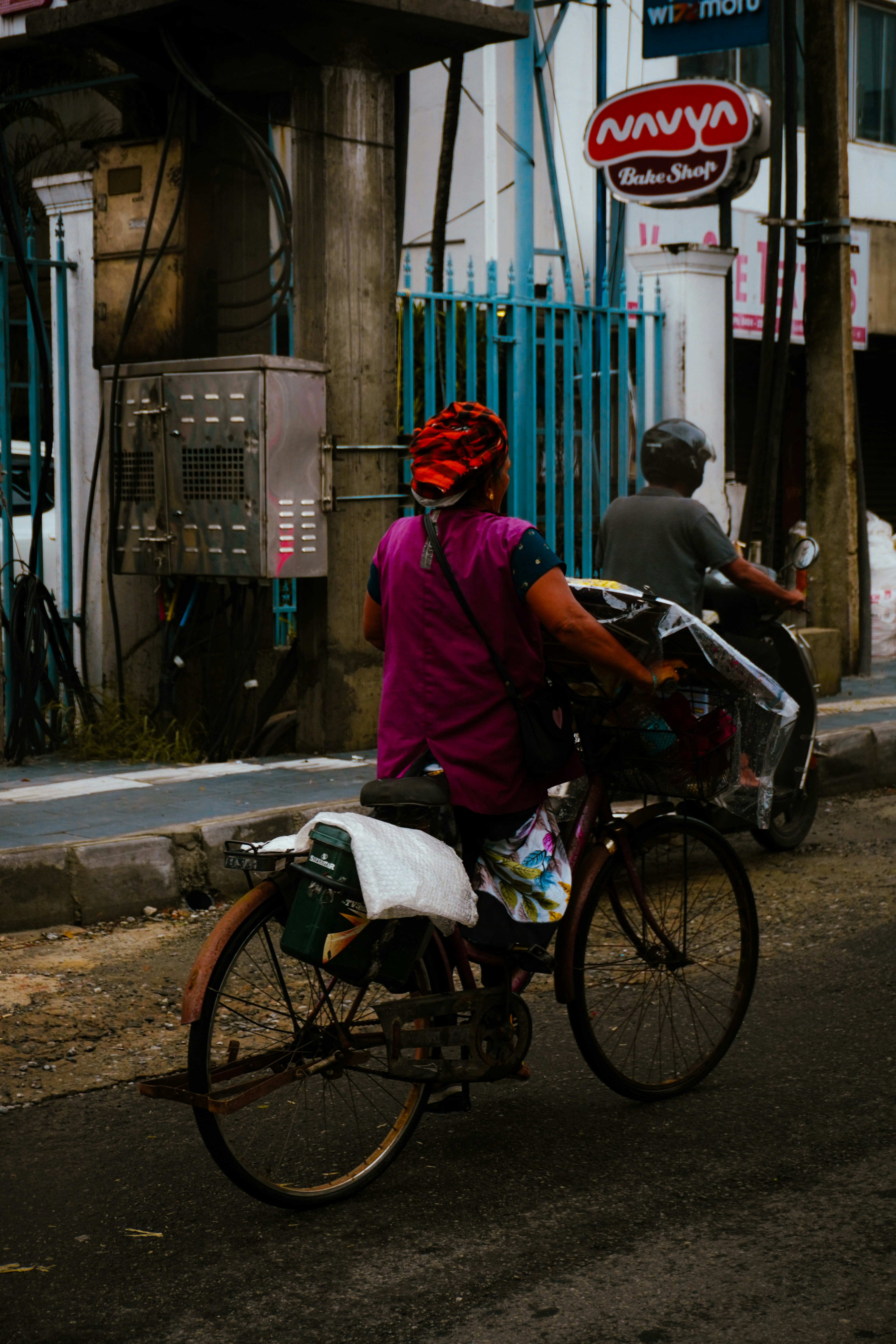 Rider in Magenta: Street Scene with a Courier and a Robotic Sign