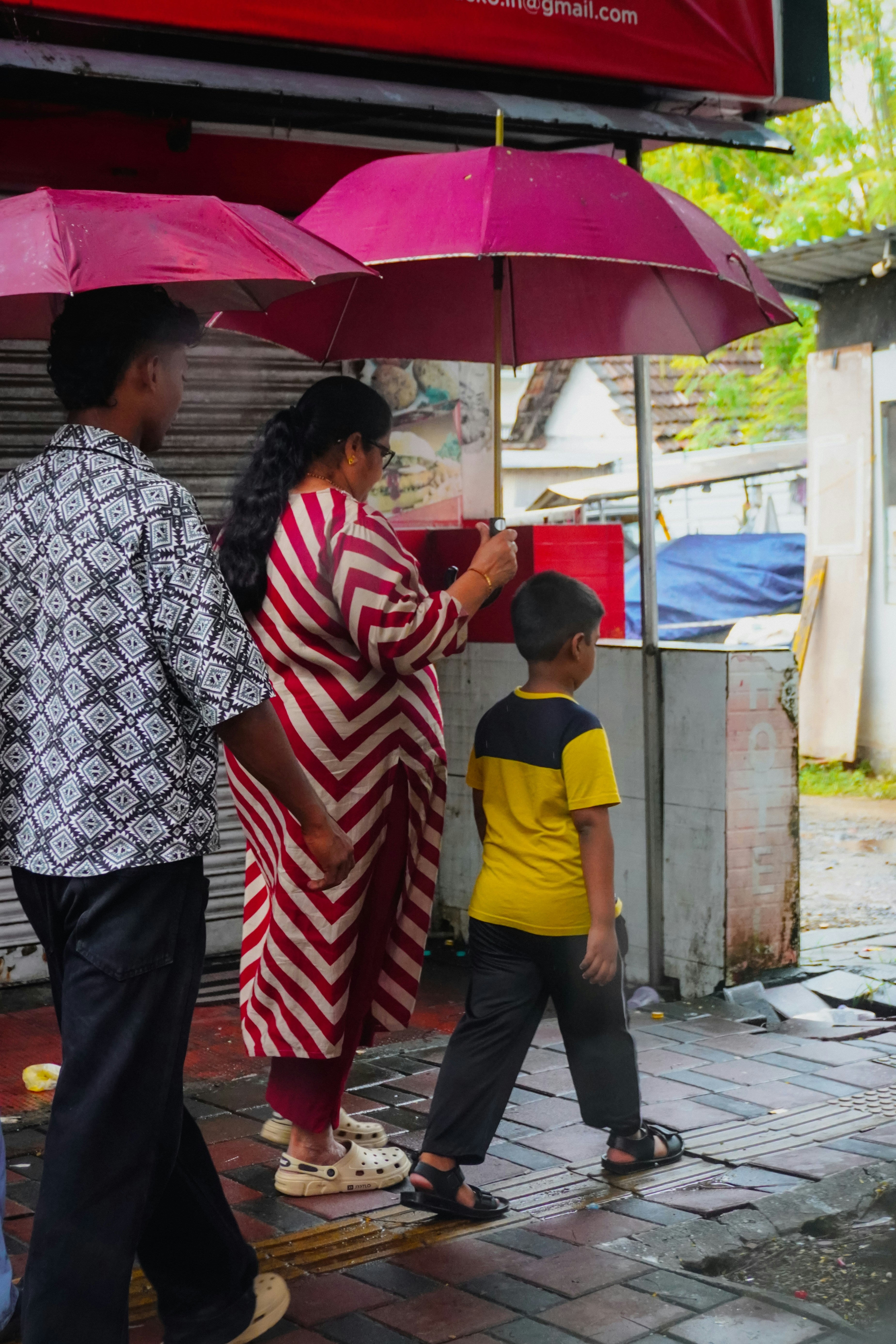 Umbrella Trust: A Family Quietly Waits Under Pink Canopy