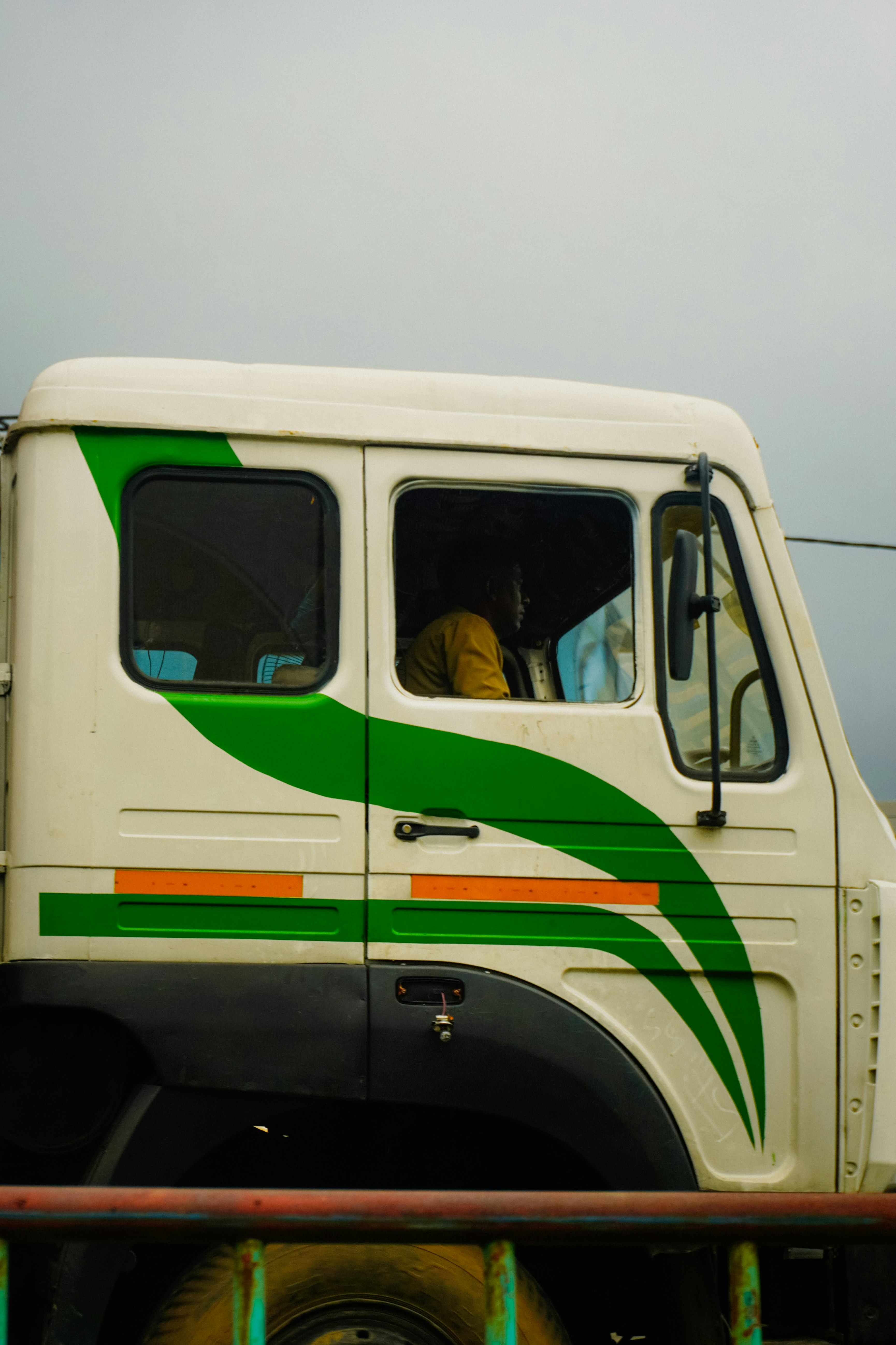 Green-streaked Truck Cab: Quiet Driver in a Moving Moment