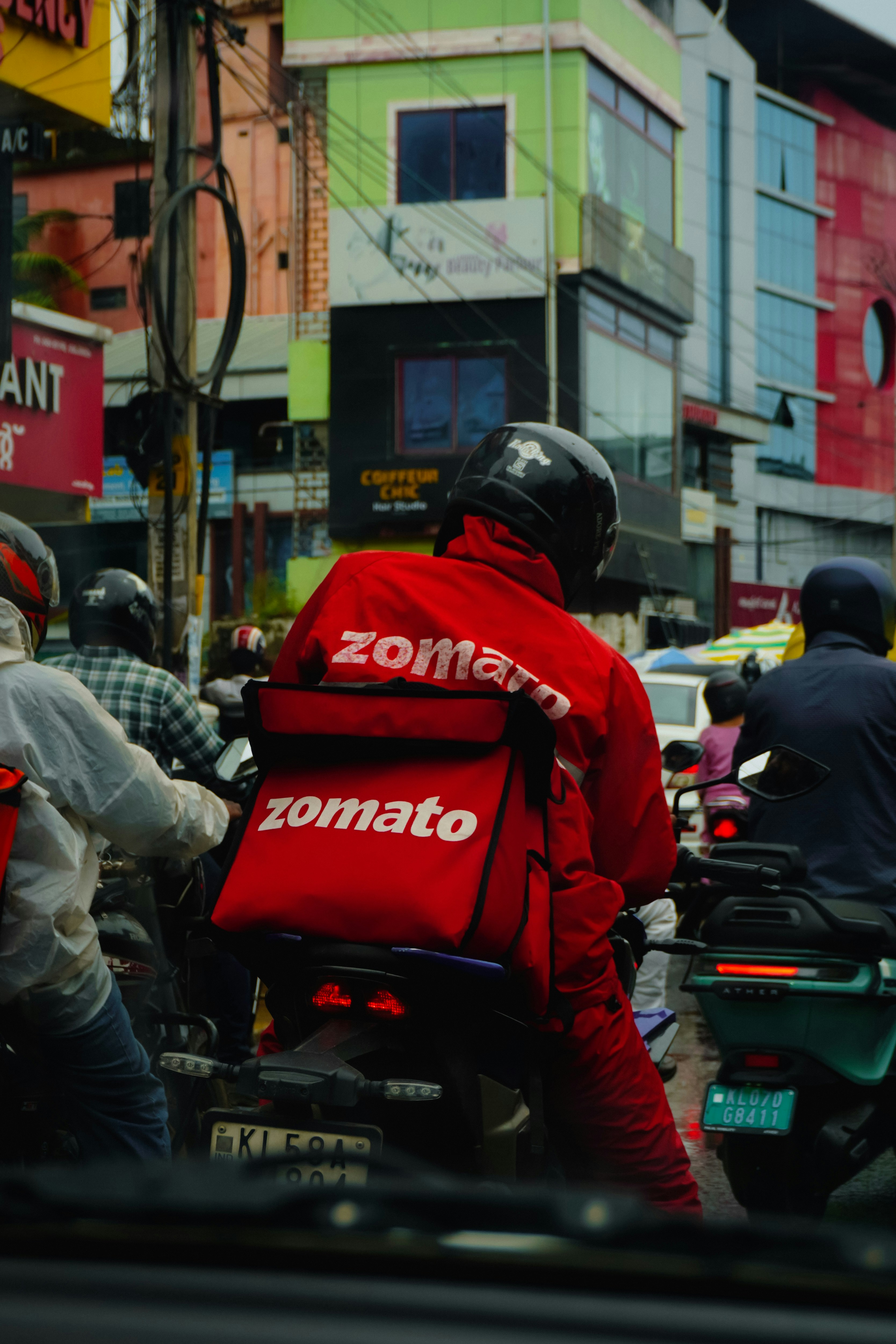 Red Zomato Courier Amidst Busy City Arteries