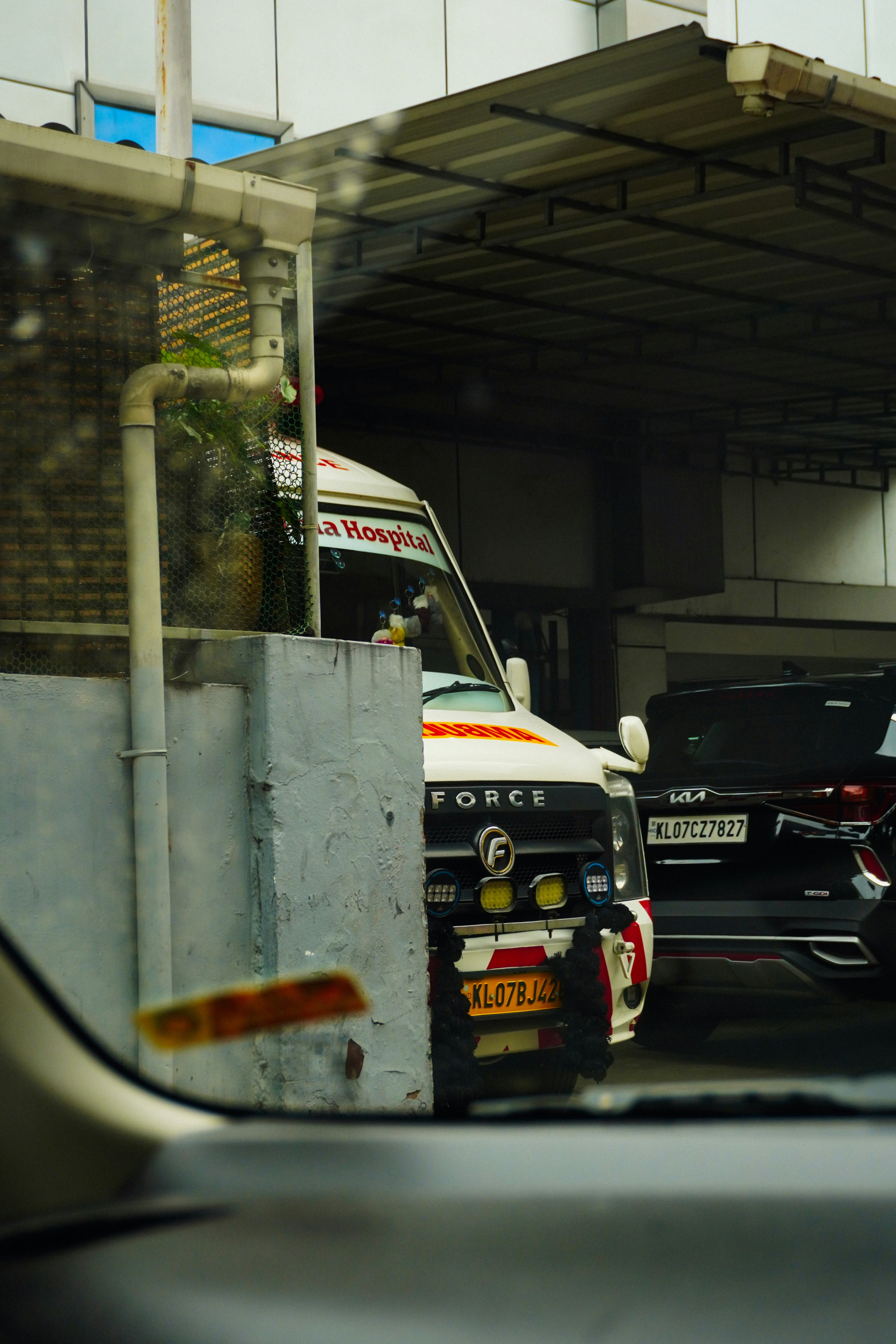 Ambulance and parked vehicles at a dimly lit loading area