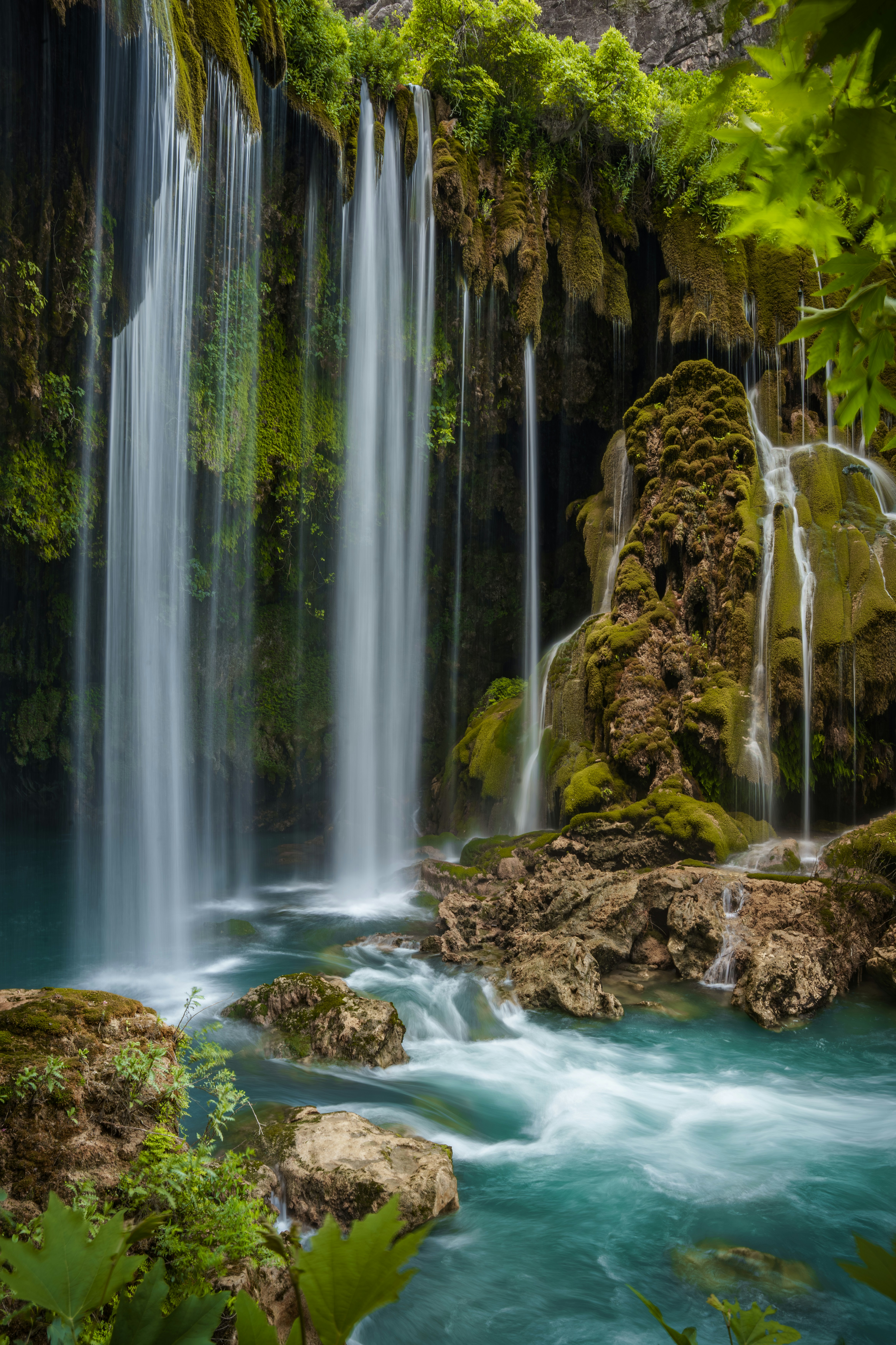Cerulean Veil: Cascades Over Mossy Cliffs