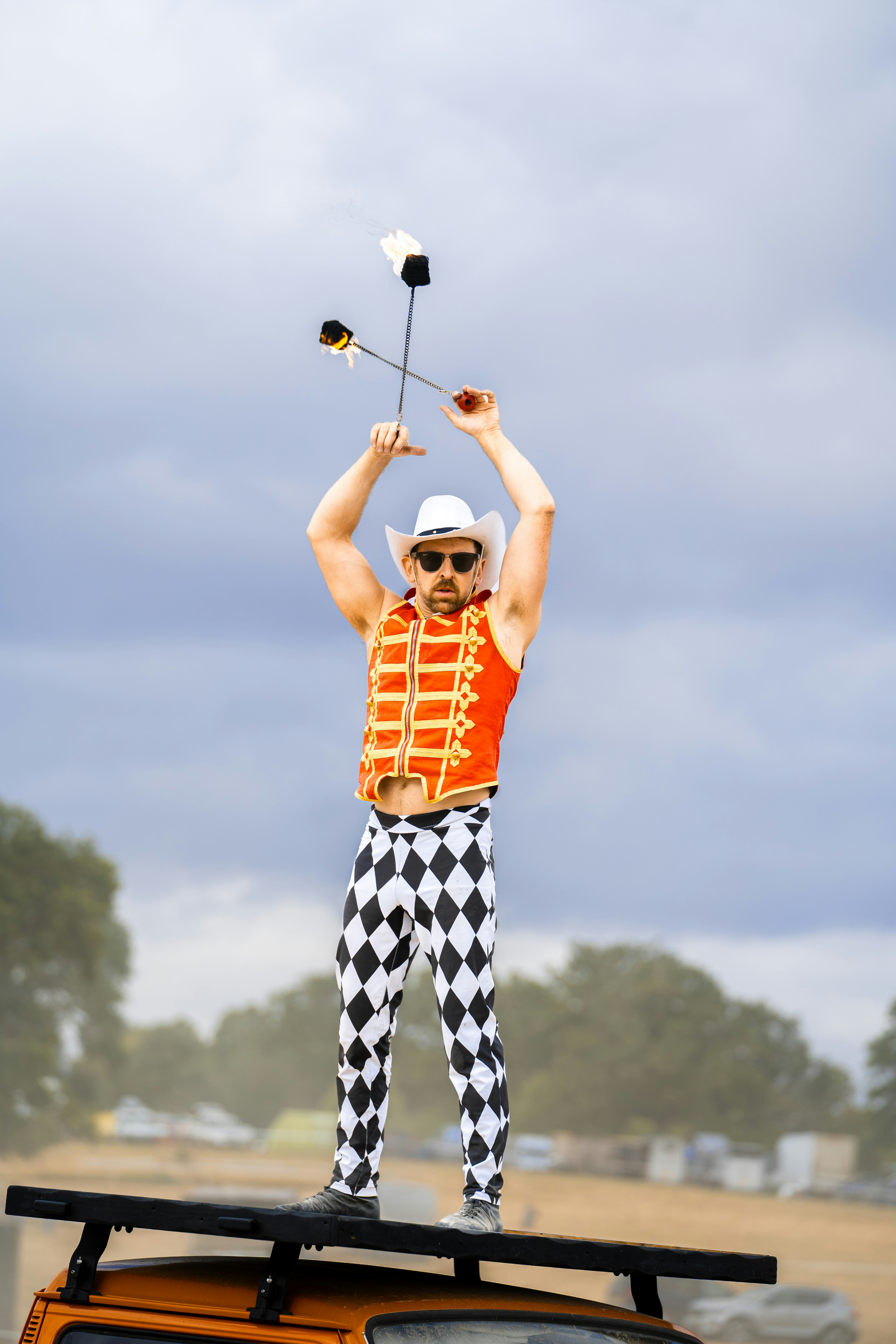 High-Wire Flamingo: A Cowboy Performer Balances Fire on a Painted Roof