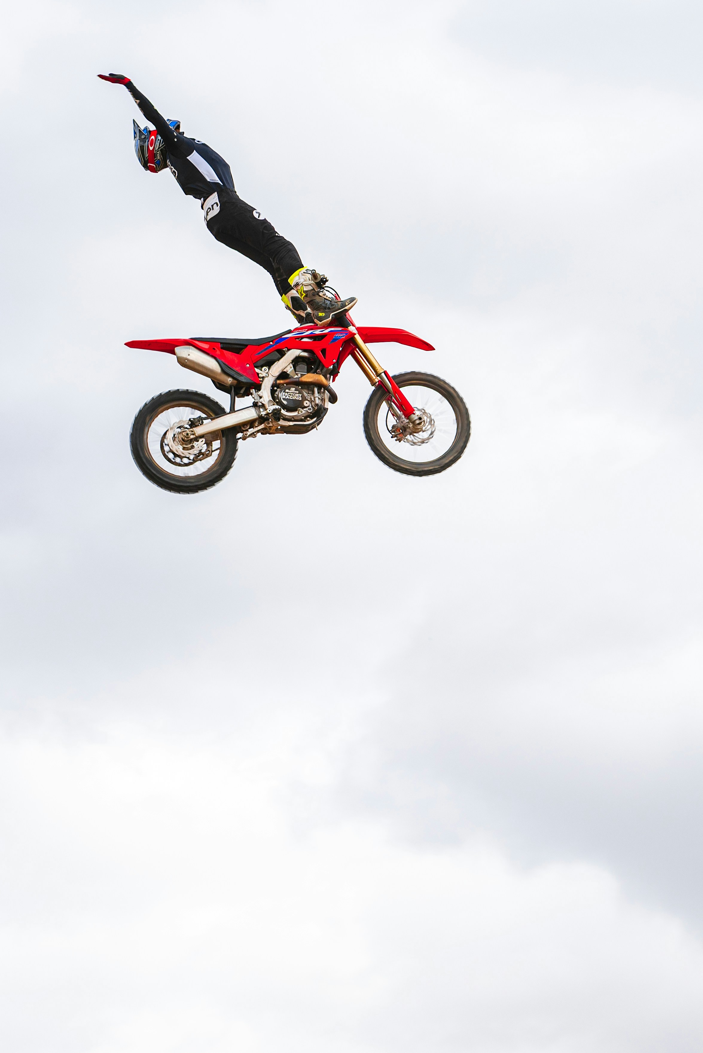 Midair Dare: Rider Launches into Sky over Red Trail Bike