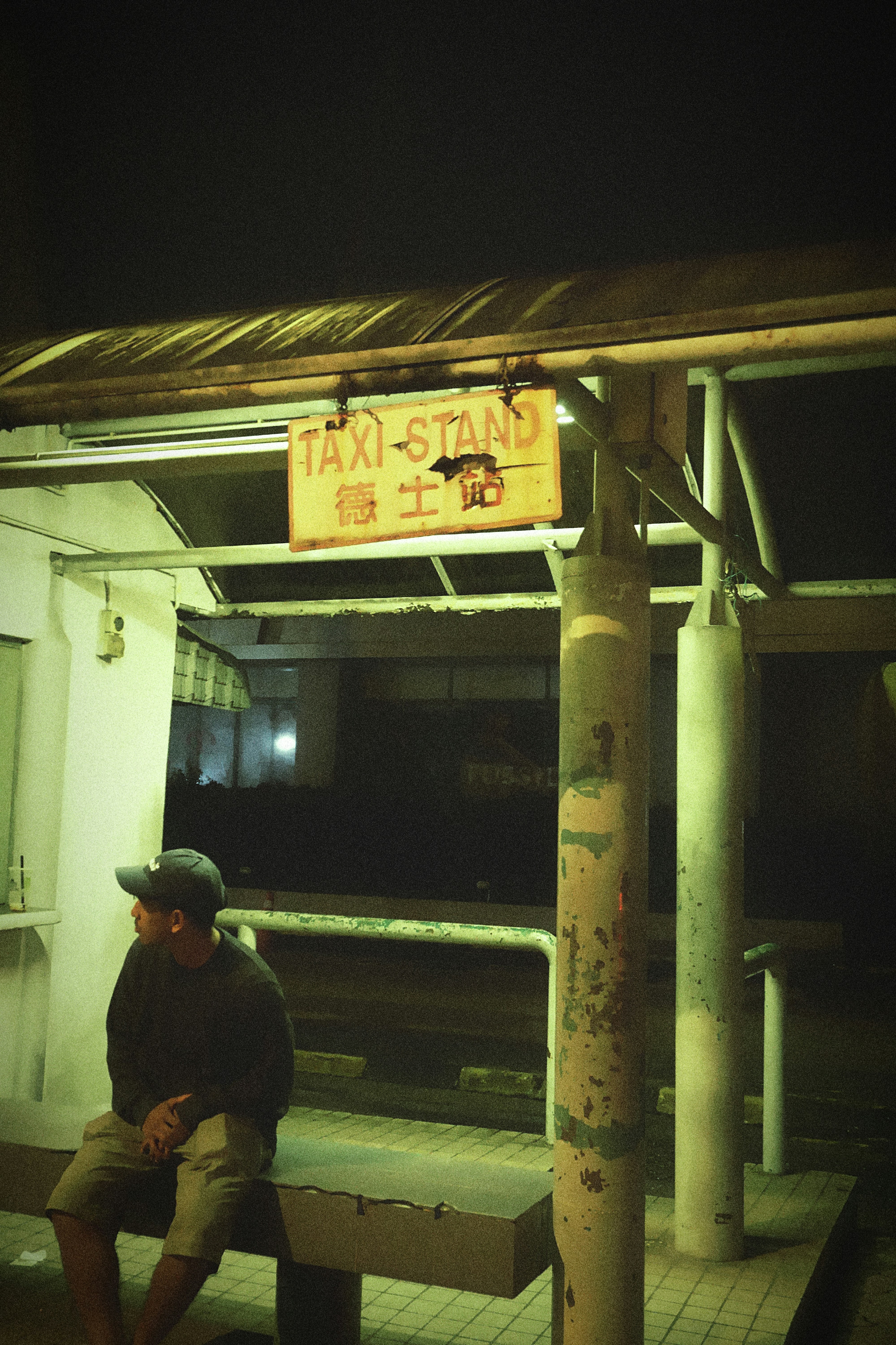 Night Station: Quiet Taxi Stand Beneath Neon Glow