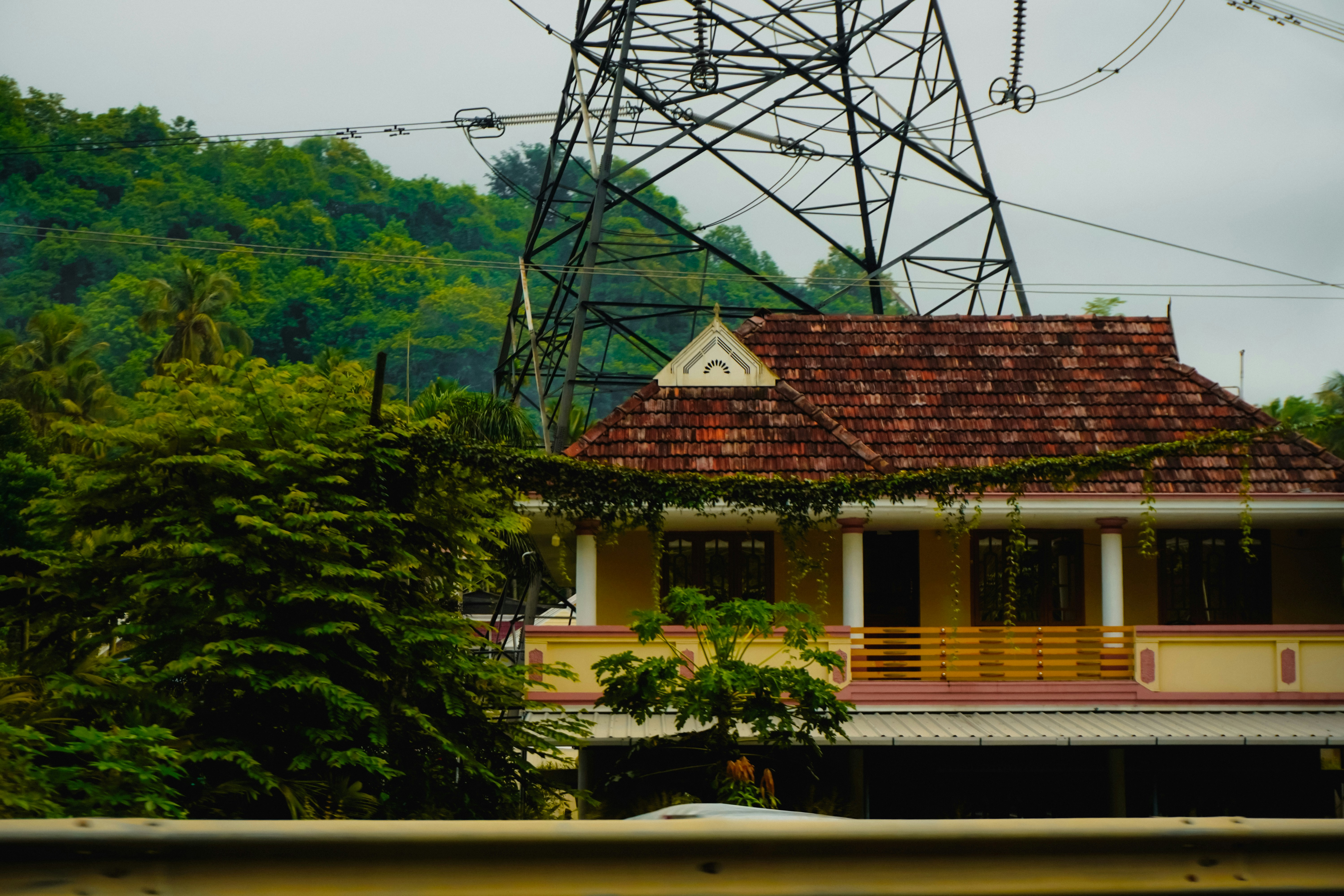 Rusted tower loom over a veranda-framed hillside home