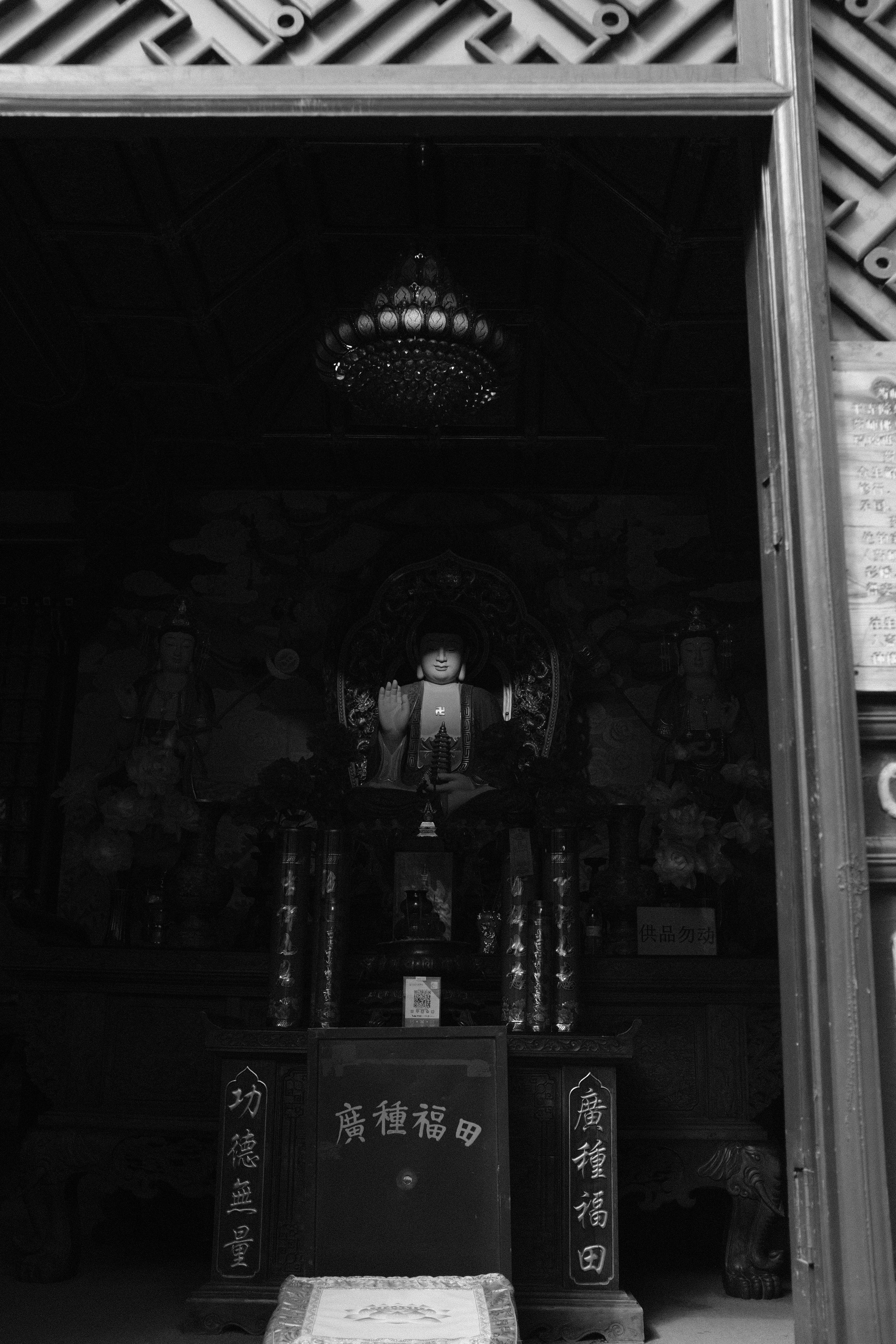 Lantern-lit Shrine: A Dimmed Interior with a Central Buddha Statue