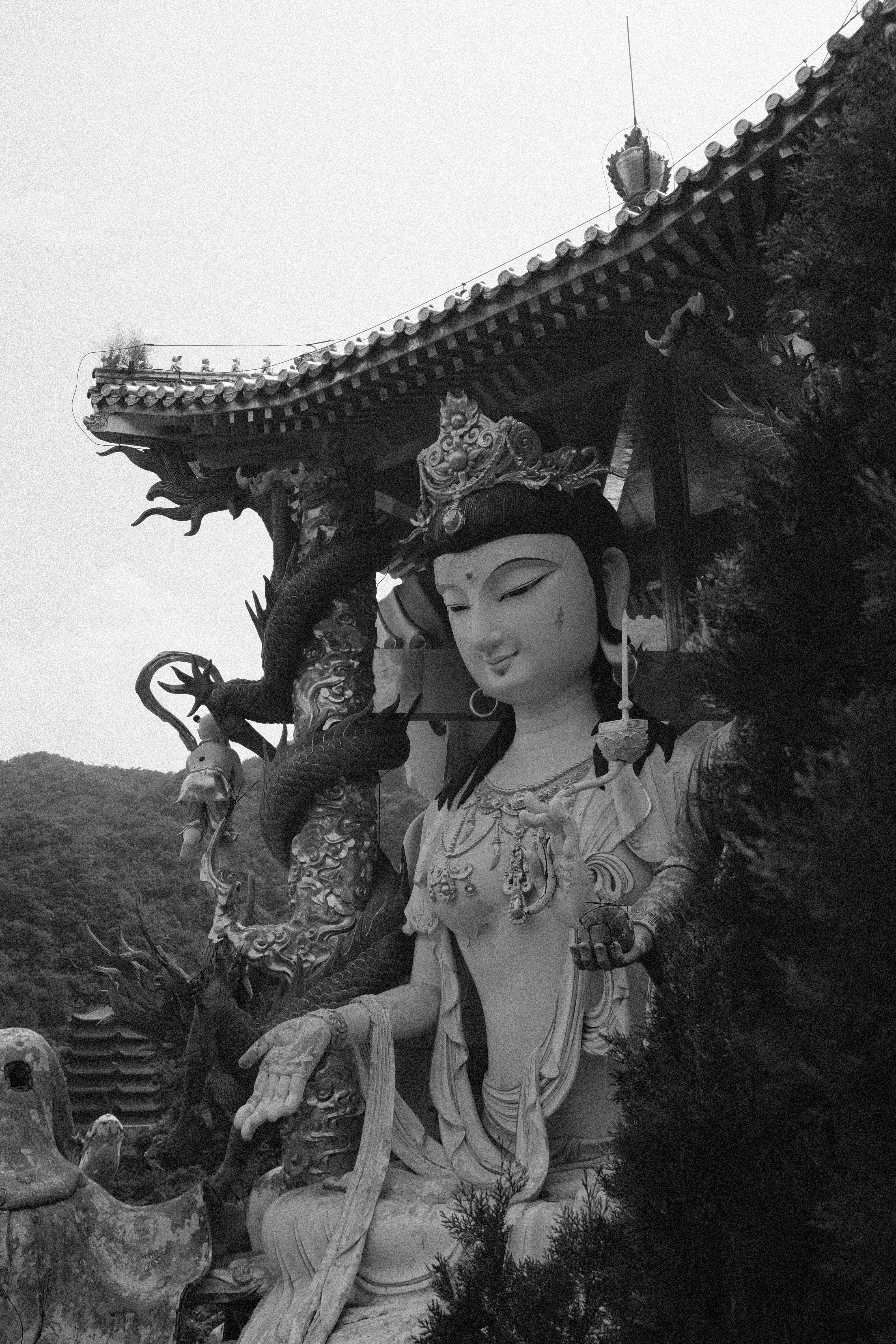 Serene Bodhisattva Adorned with Dragon Guardians Beneath an Ornate Pavilion