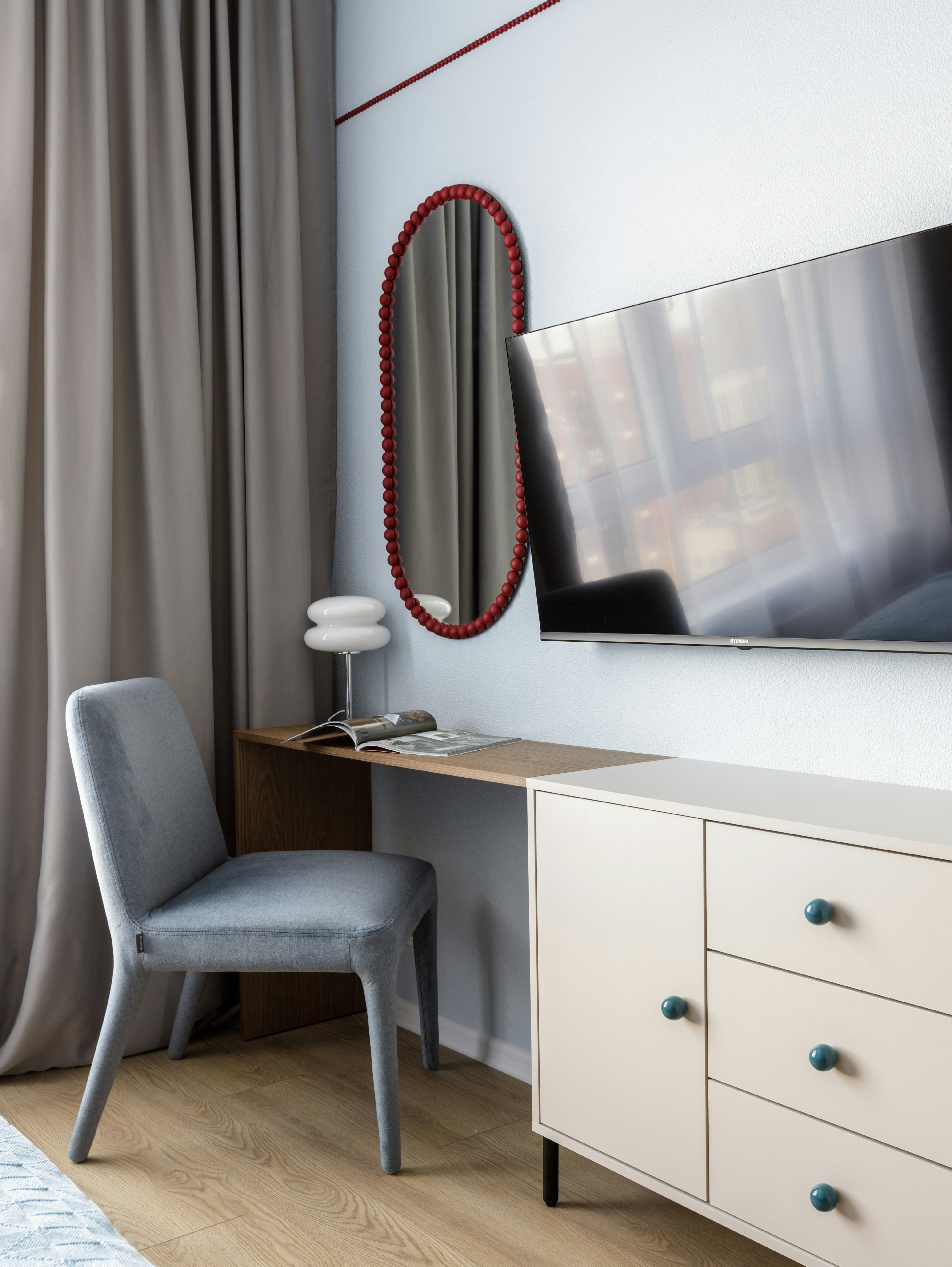 Muted hotel-room vignette: chair, dresser, and angled TV