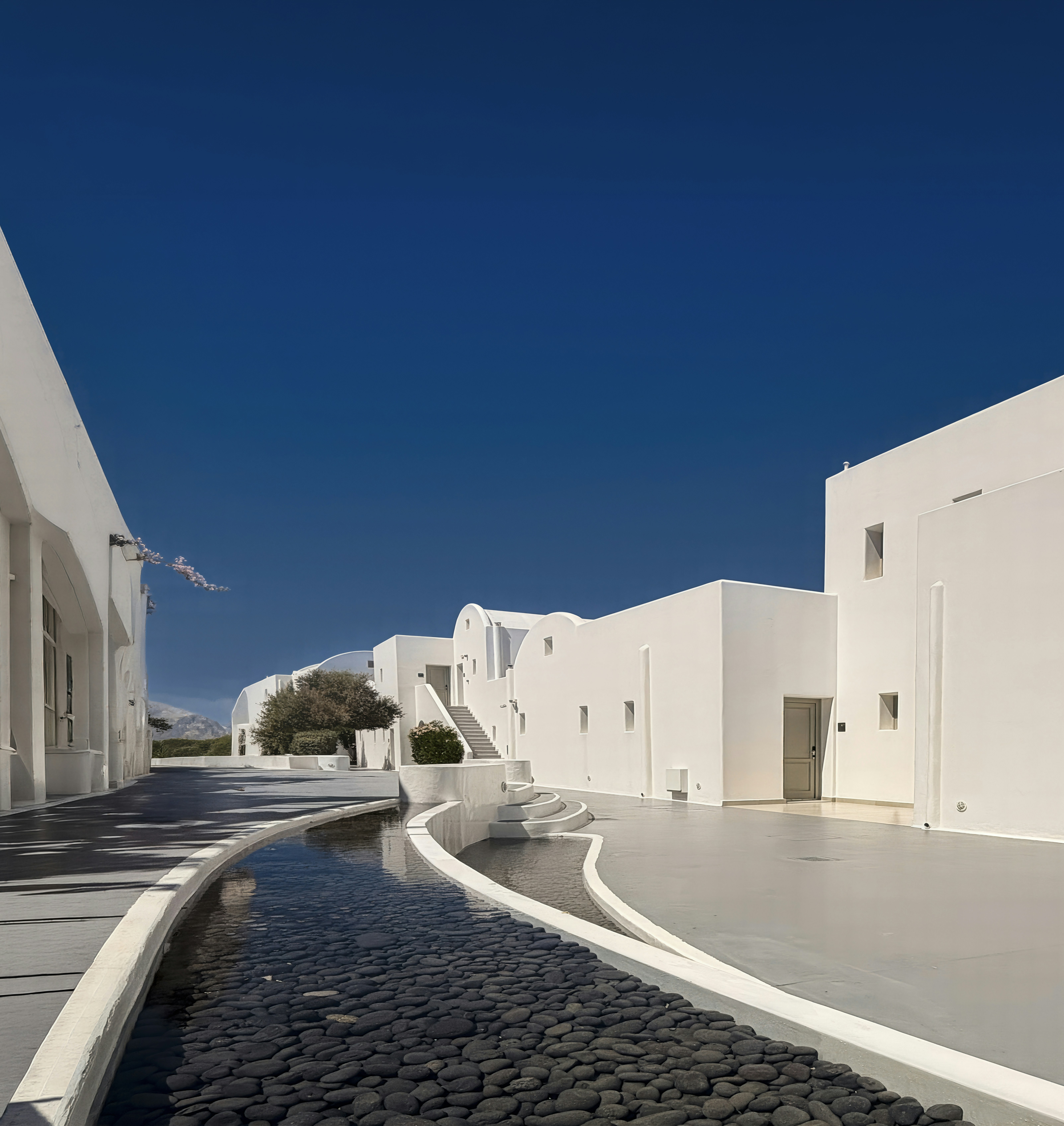 Whitewashed Architecture Along a Curved Water Channel