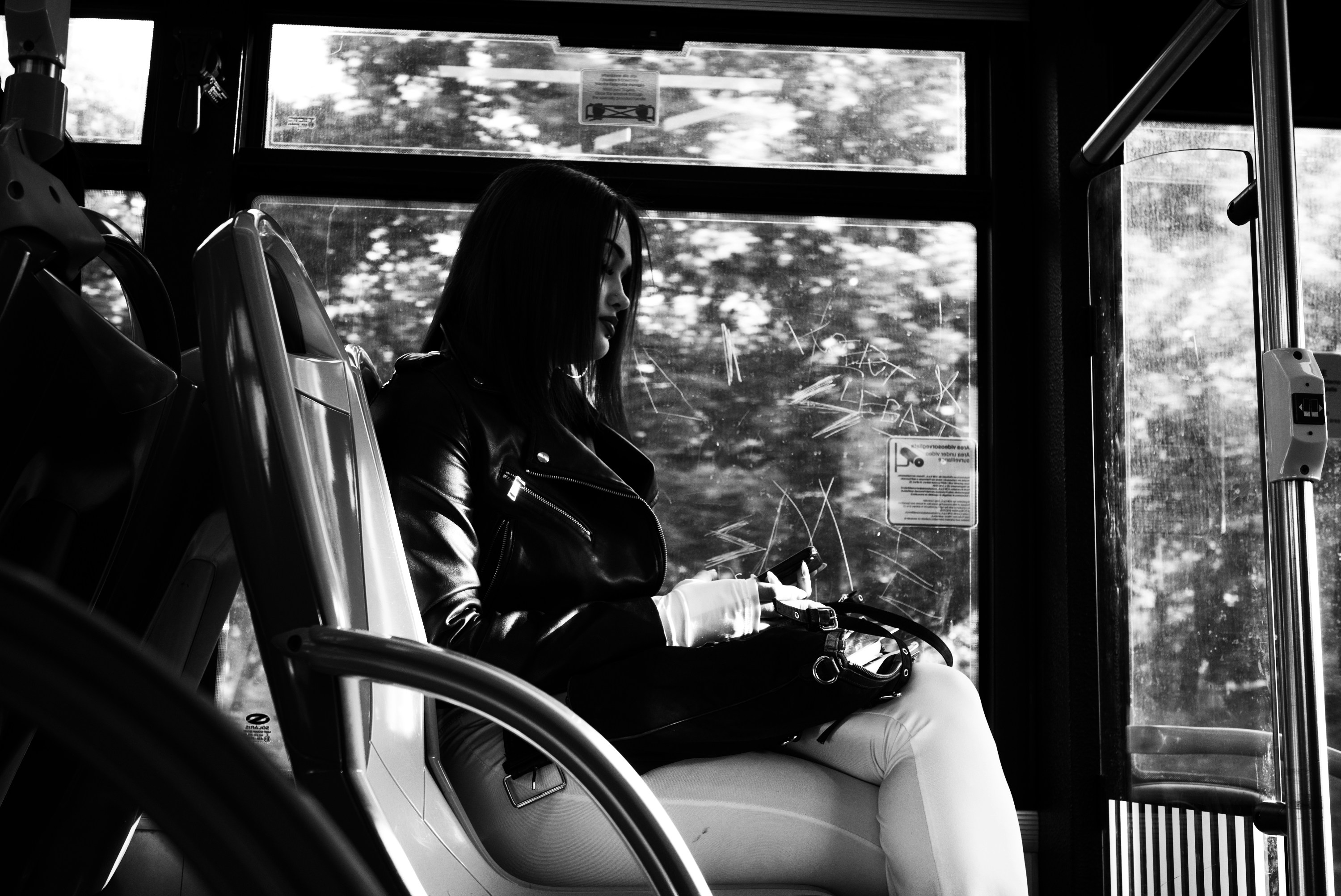Portrait on a Quiet Bus: A Woman in a Leather Jacket with Earbuds