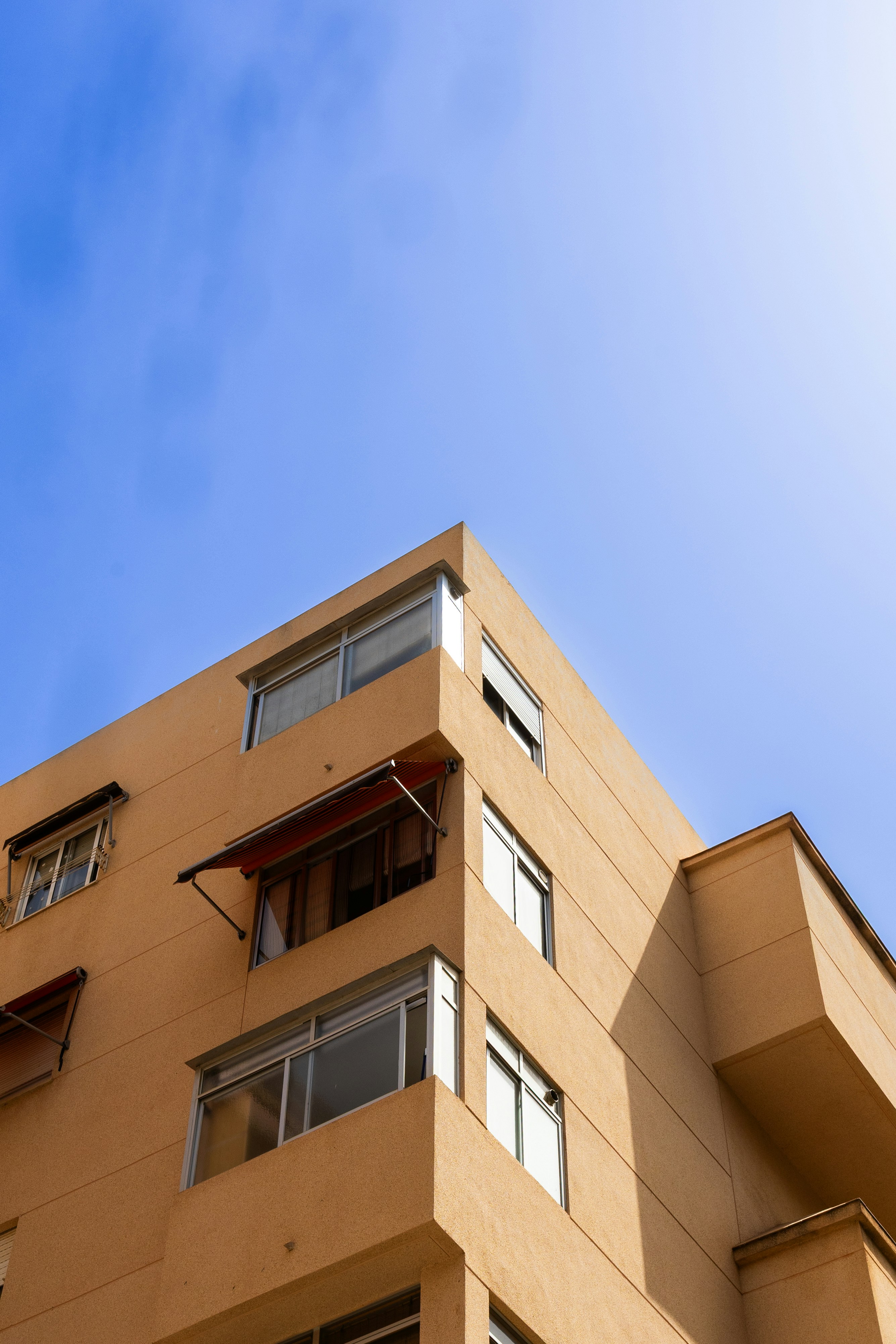 Orange Apartment Facade Reaching Toward a Clear Sky