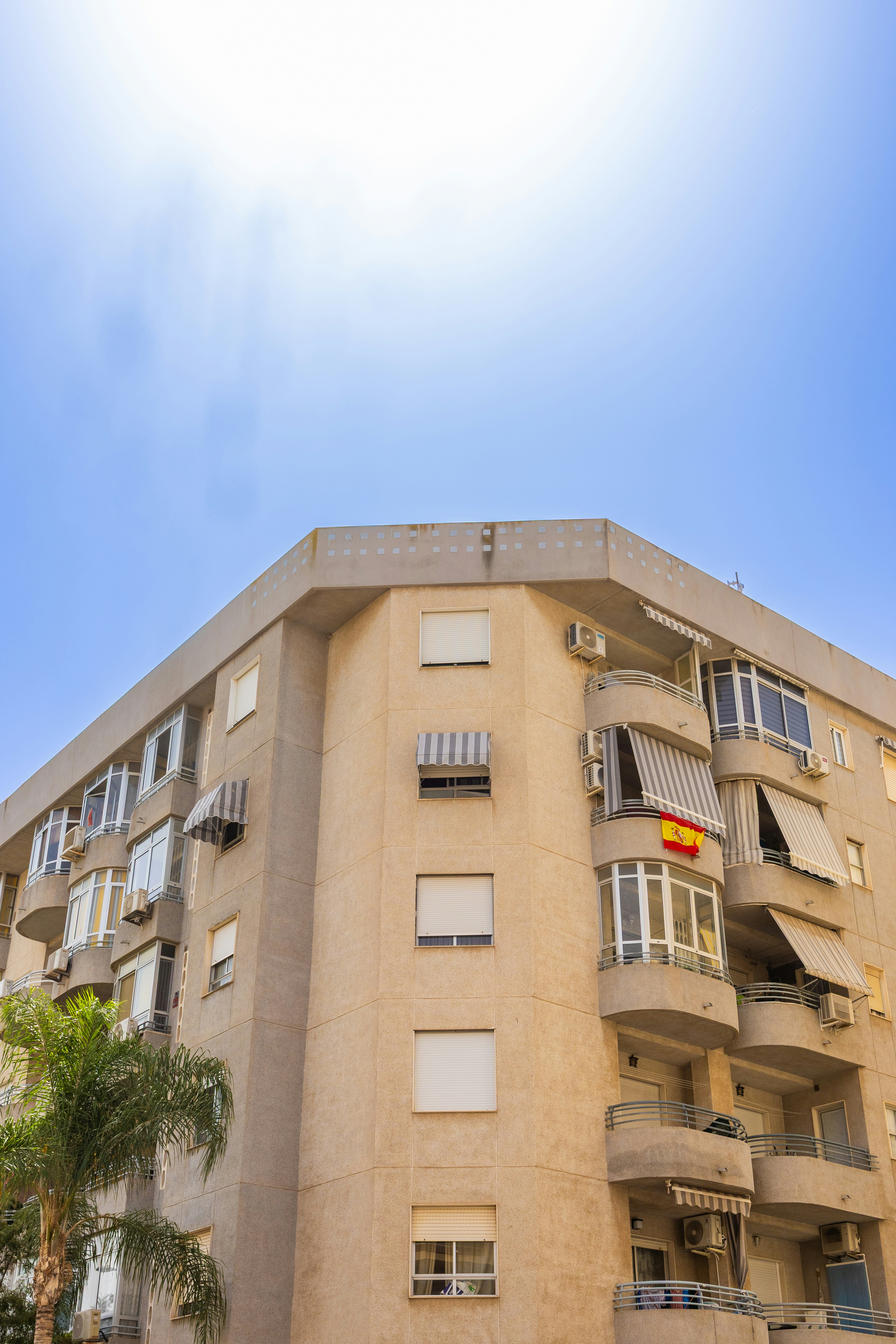 Sunlit Corner: A Coral Beige Residential Block Reaches for the Sky