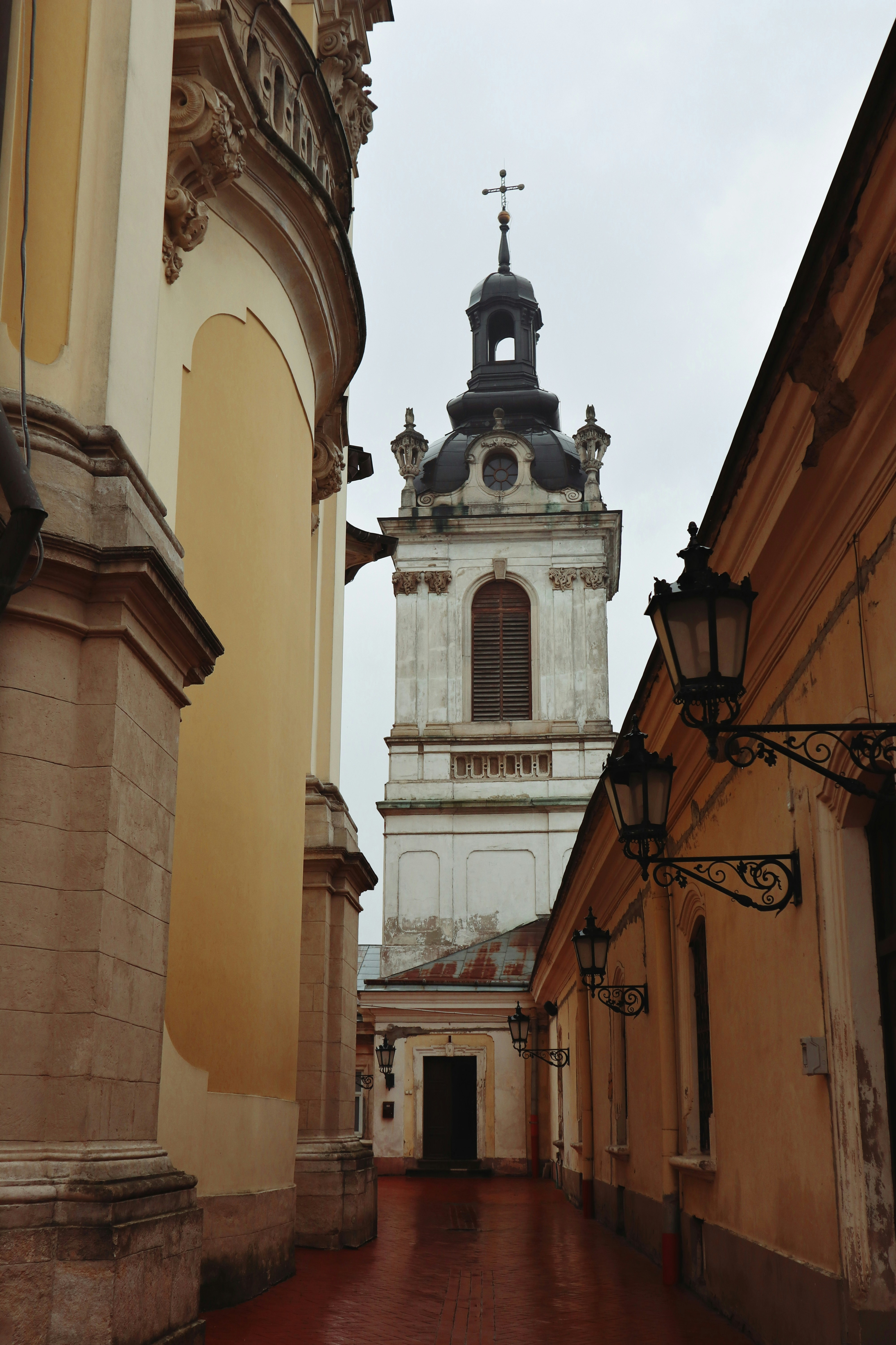 Clocktower against a narrow alley of ochre and stone