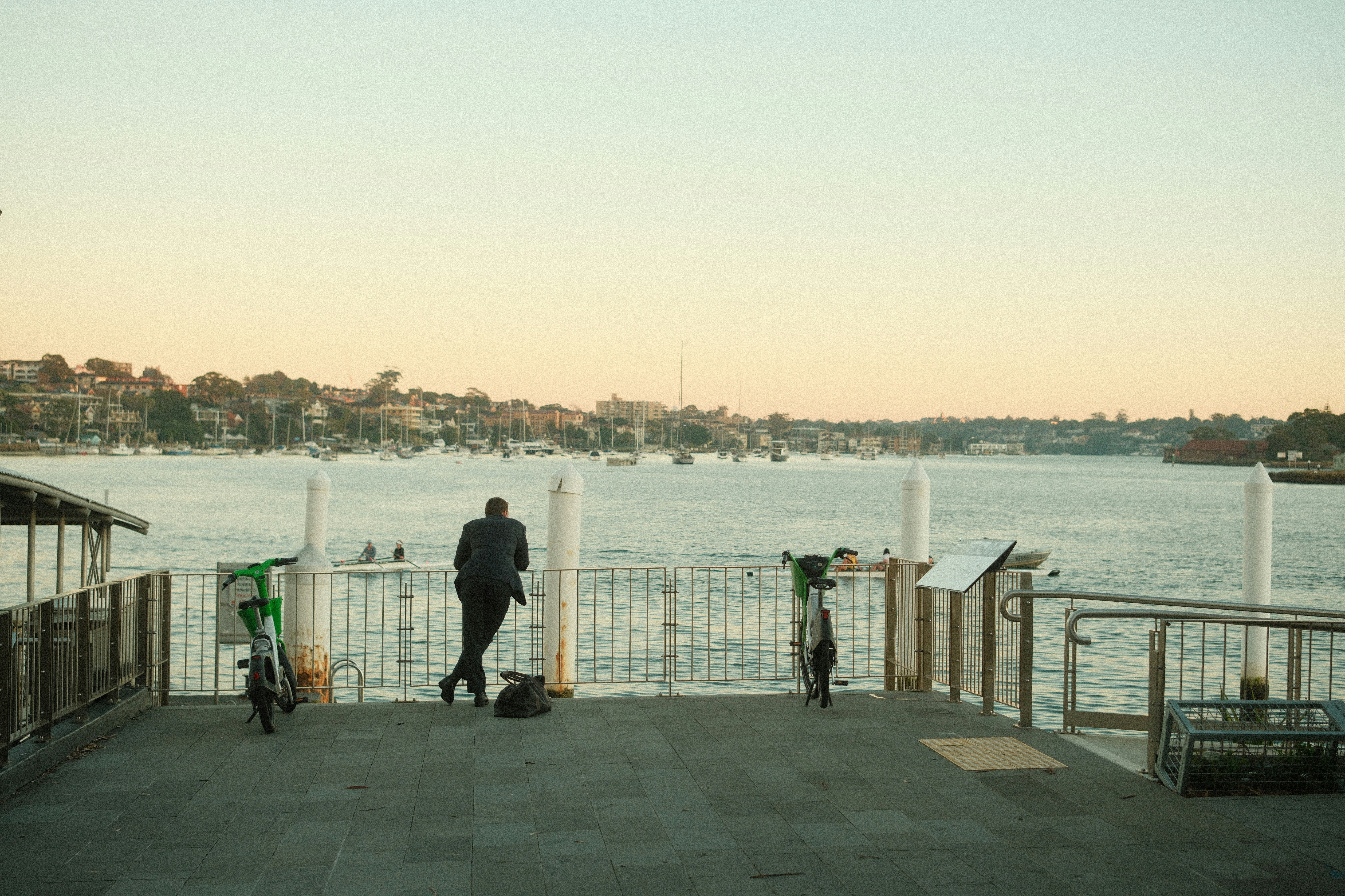 Quiet Moment at the Waterfront: A Person with Bag Waiting by the Docks