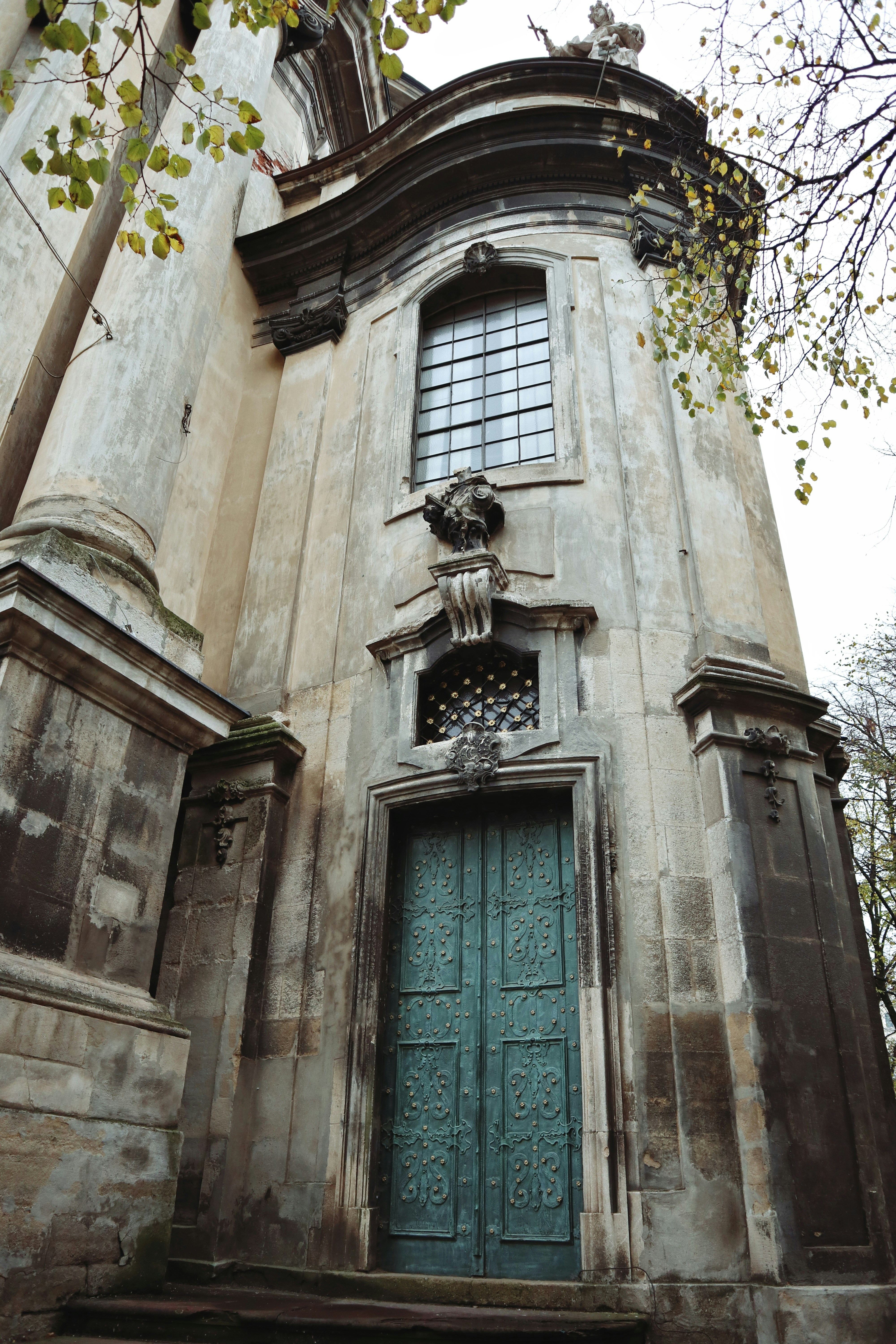 Weathered Baroque Facade: An Aged Doorway Framed by Stone Arches
