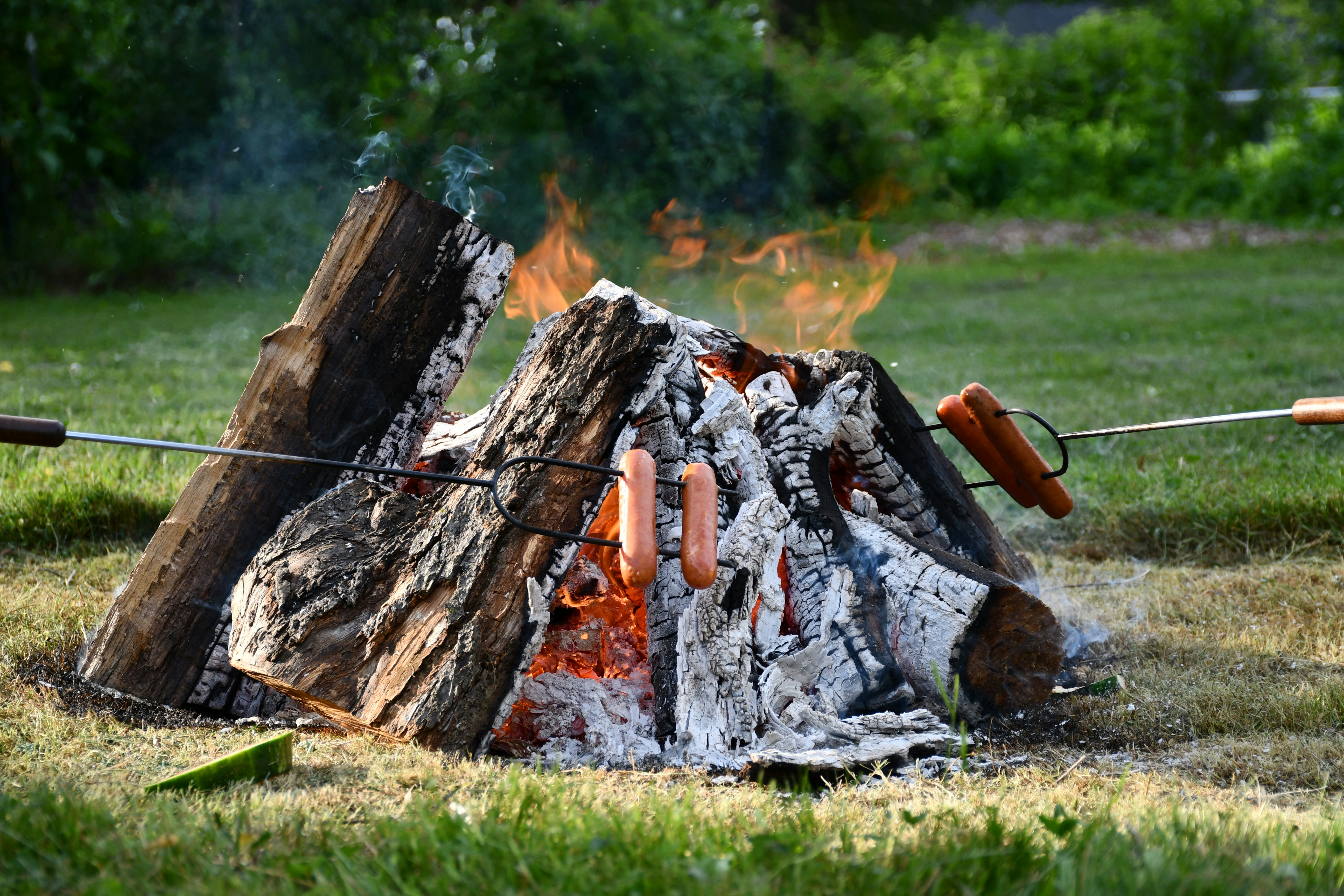 Grill-line Fire: Sausages Sizzle Over Ember-Coated Logs