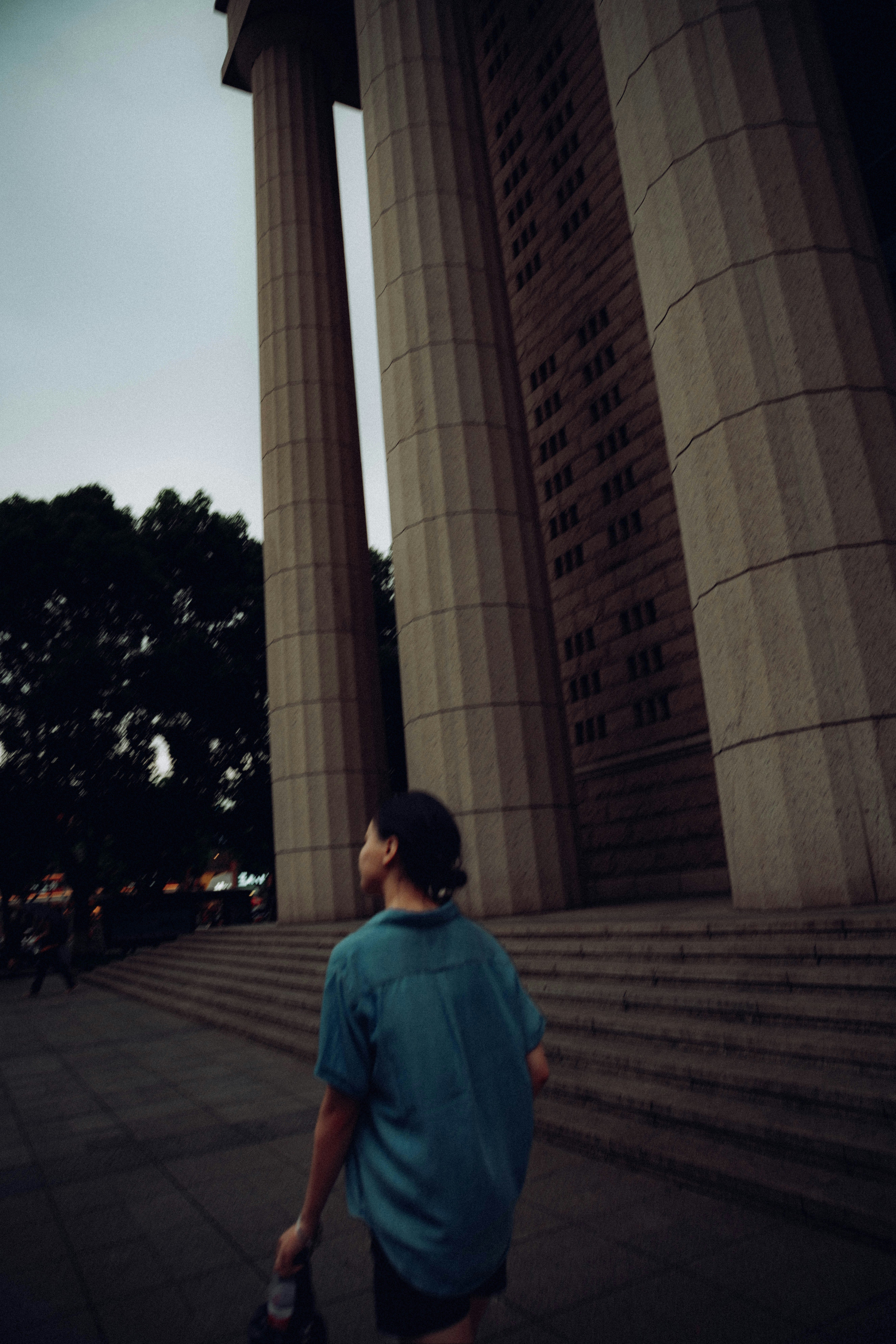 Traveler in a Blue Shirt Descends the Steps of a Monumental Facade